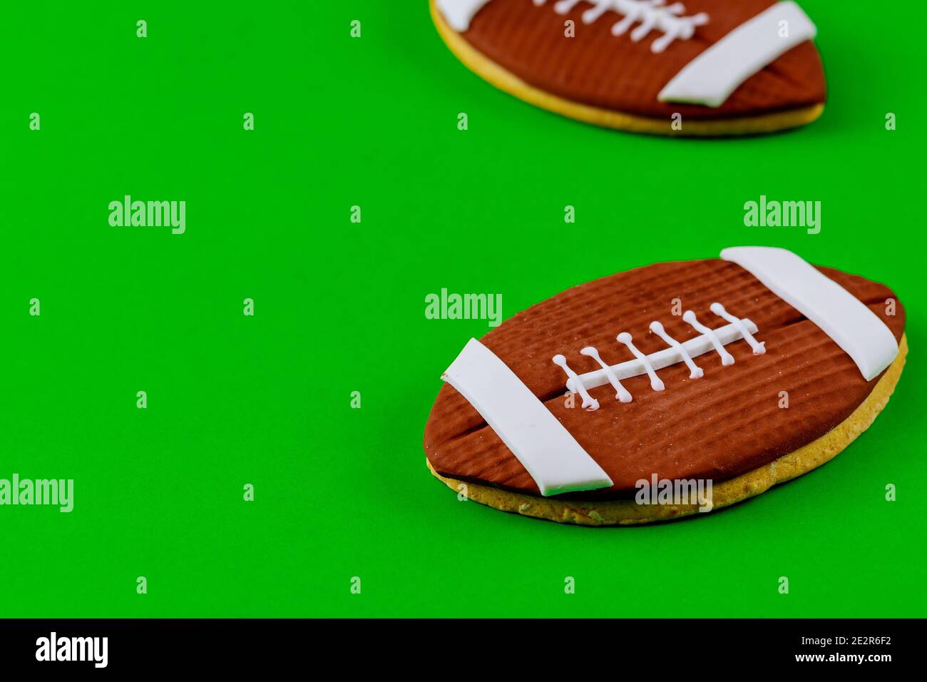 Rugby ball cookie on green background. American football background ...