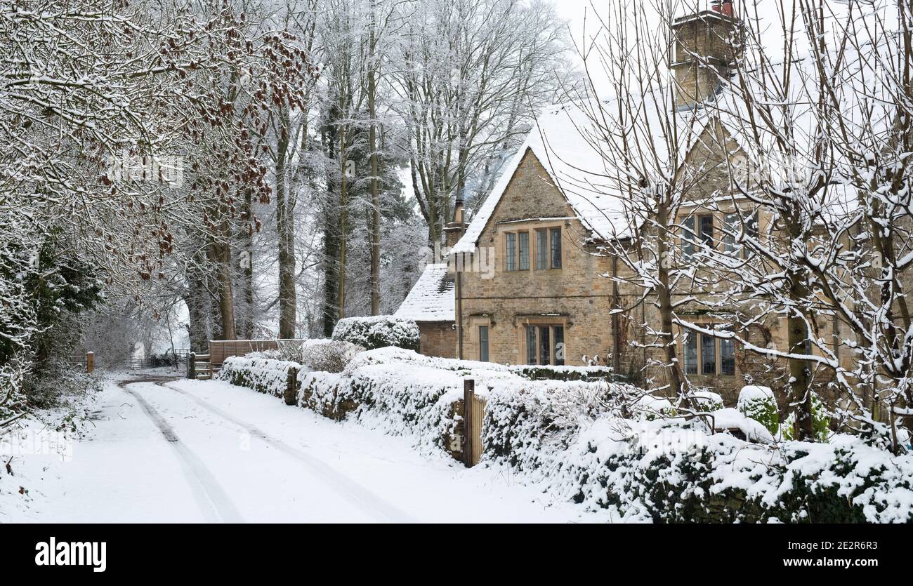 Cotswold stone cottage, trees and track in the december snow in the ...