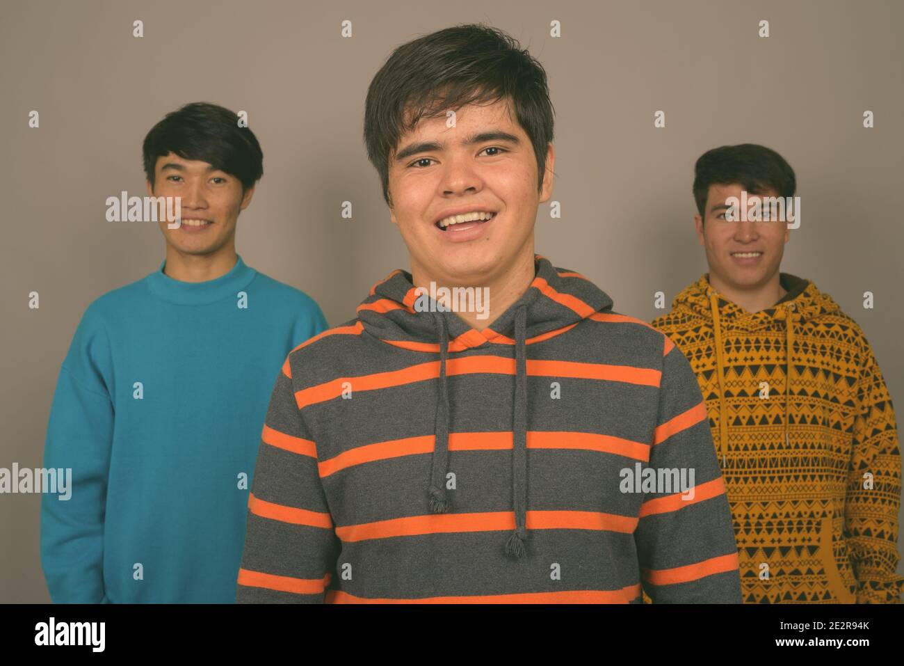 Three young Asian friends together against gray background Stock Photo ...