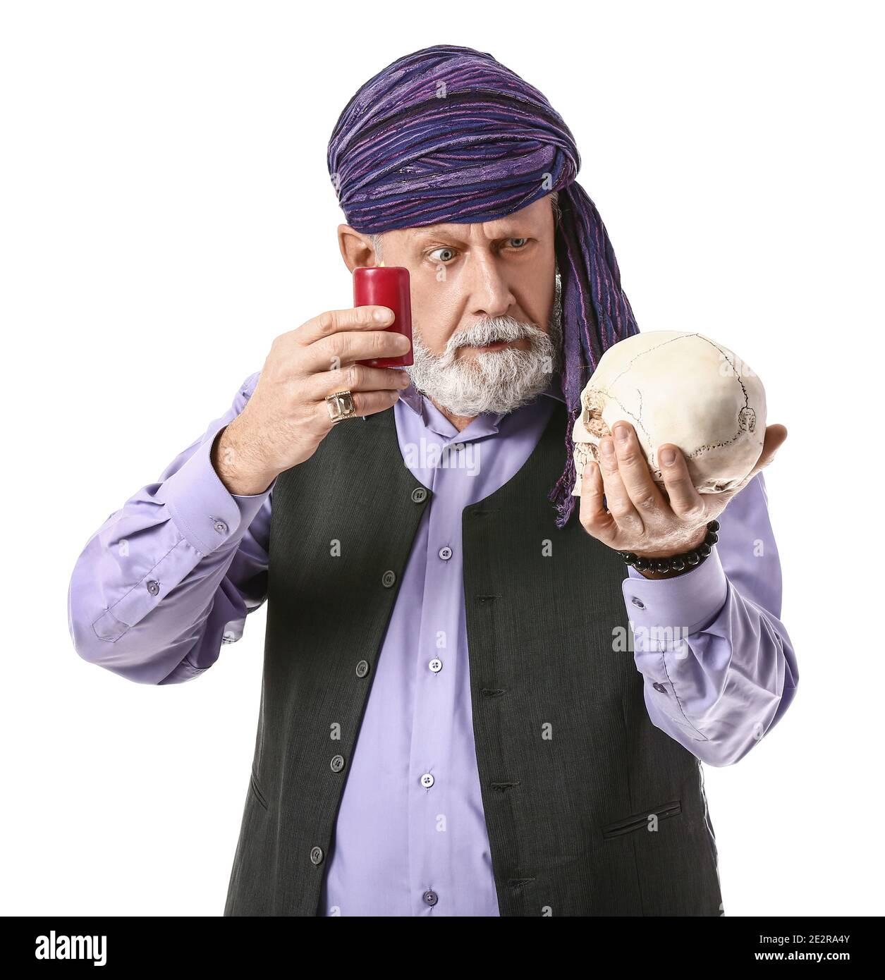 Male fortune teller with candle and human skull on white background ...