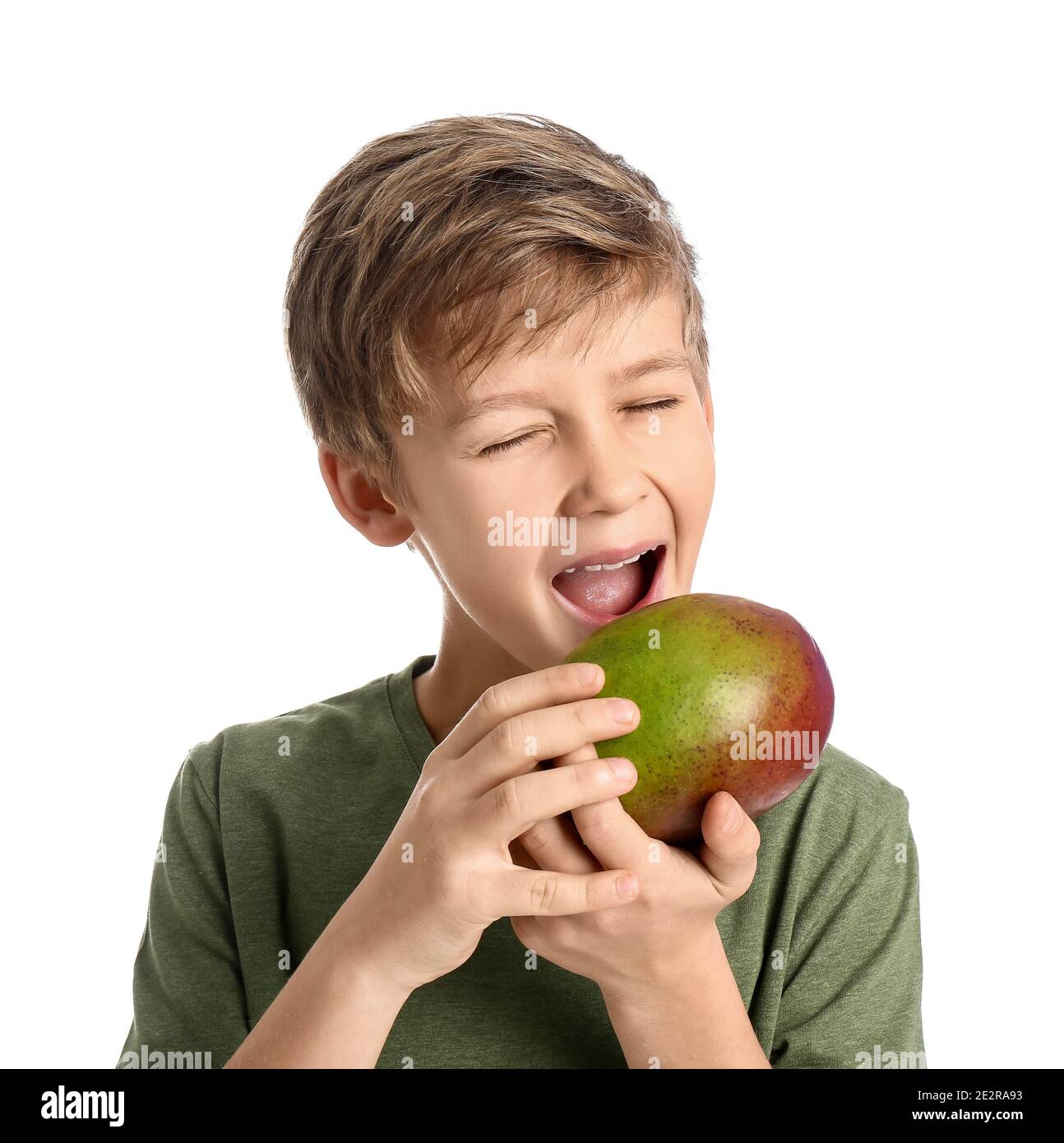 Cute little boy eating fresh tasty mango on white background Stock ...