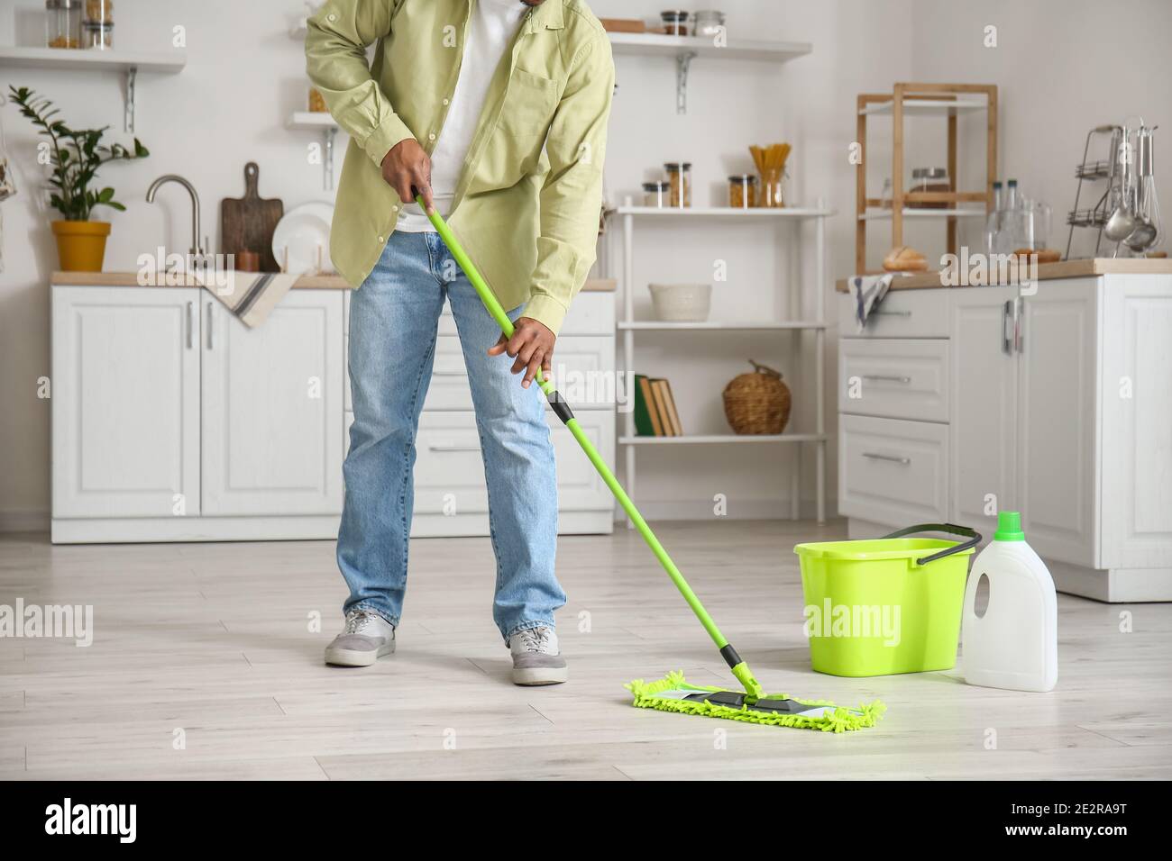 African-American man mopping floor in kitchen Stock Photo - Alamy
