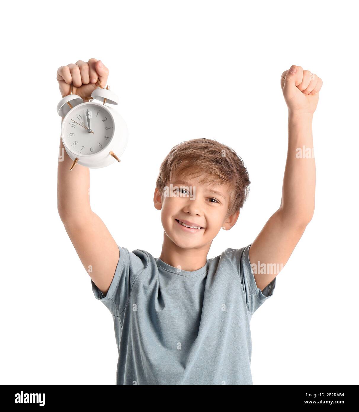 Happy little boy with alarm clock on white background Stock Photo - Alamy