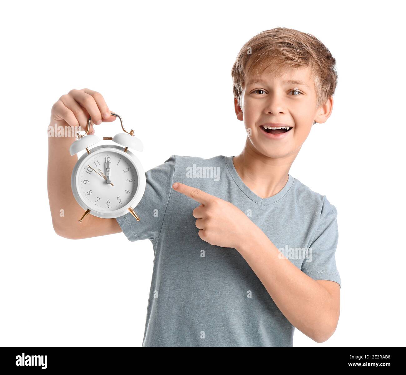 Little boy with alarm clock on white background Stock Photo - Alamy