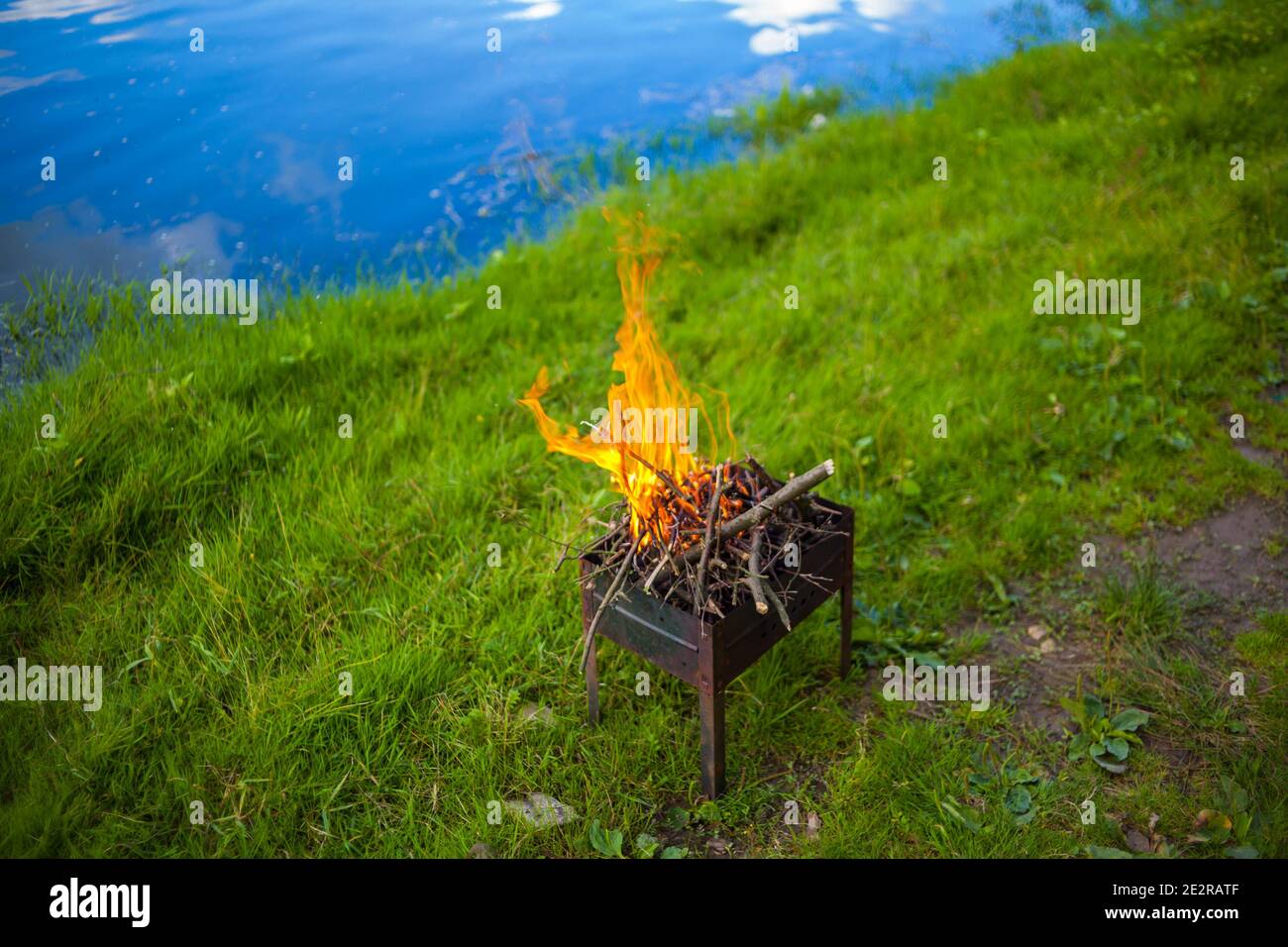 A small folding portable brazier filled with burning wood Stock Photo ...