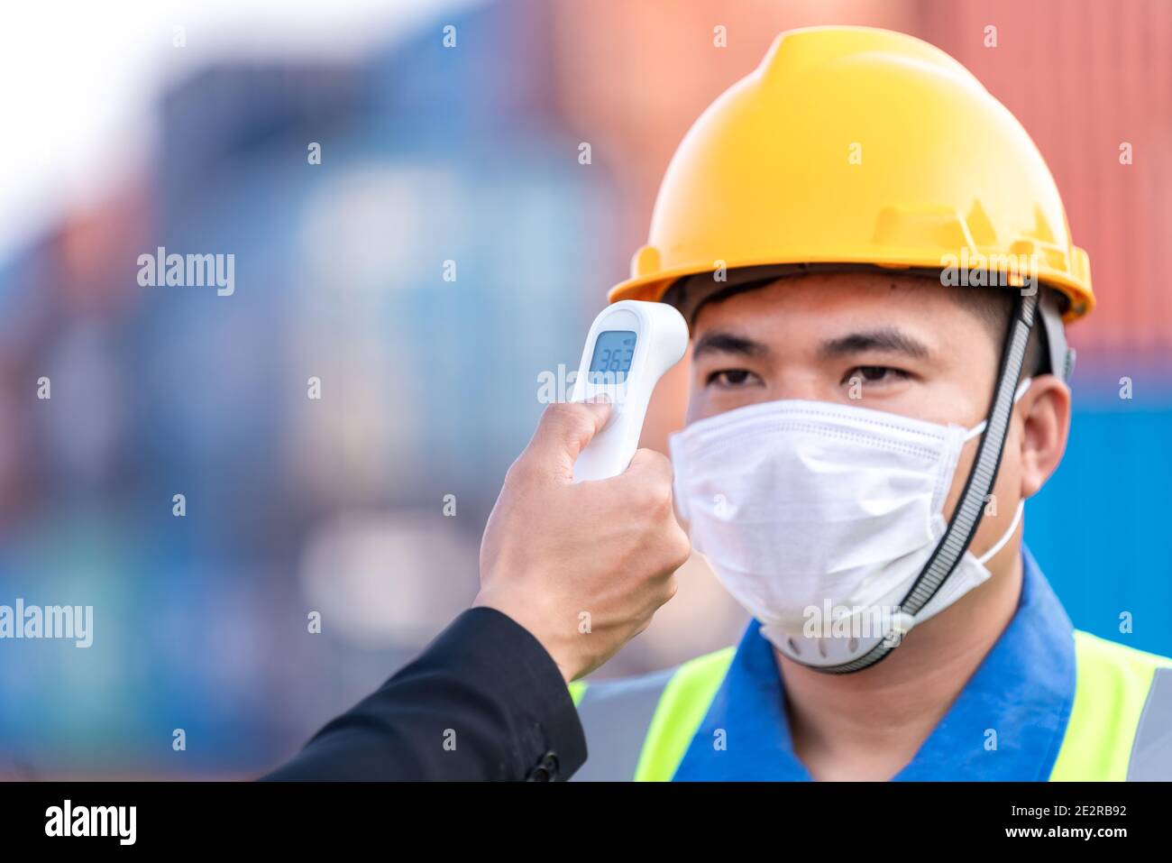 Close up asian worker scanning fever temperature with digital ...