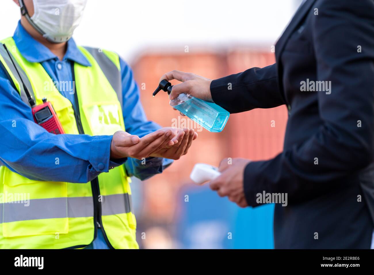Worker wash your hands with gel and scanning fever temperature with ...