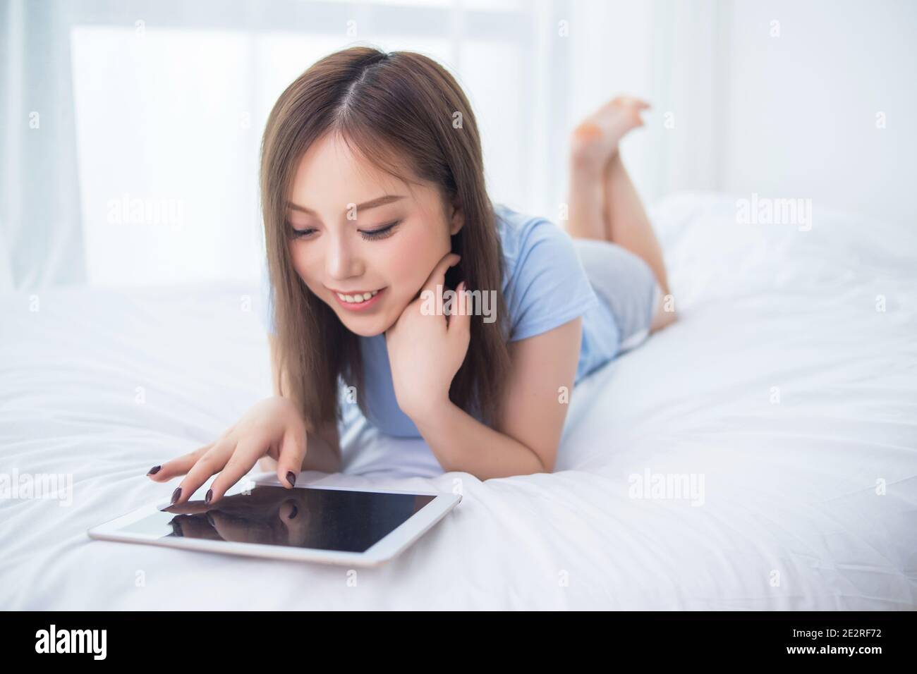 Woman use pad on bed Stock Photo - Alamy
