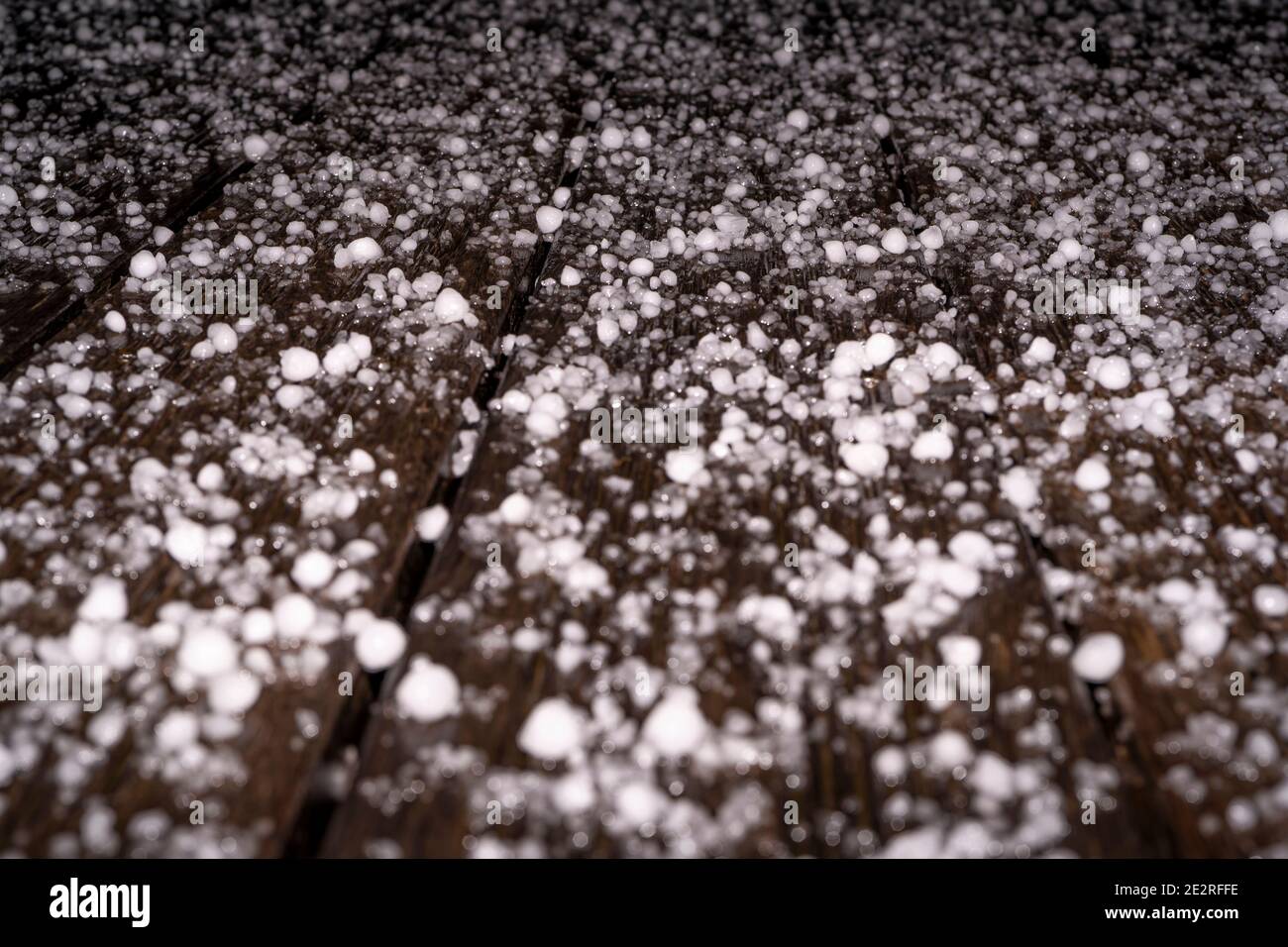Large grains of hail on a black background. Background, texture. After ...