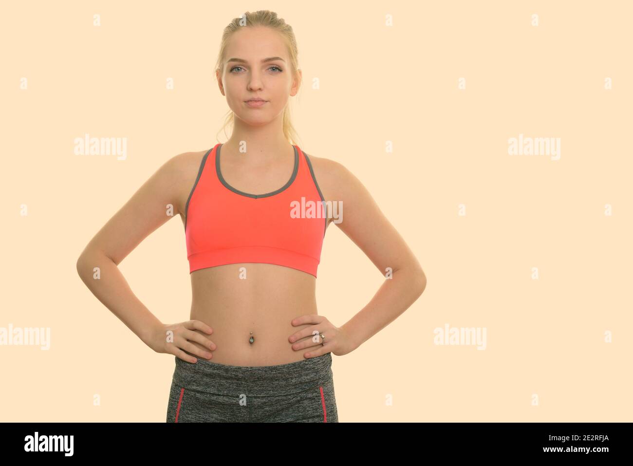 Studio shot of young beautiful teenage girl with hands on hips ready ...