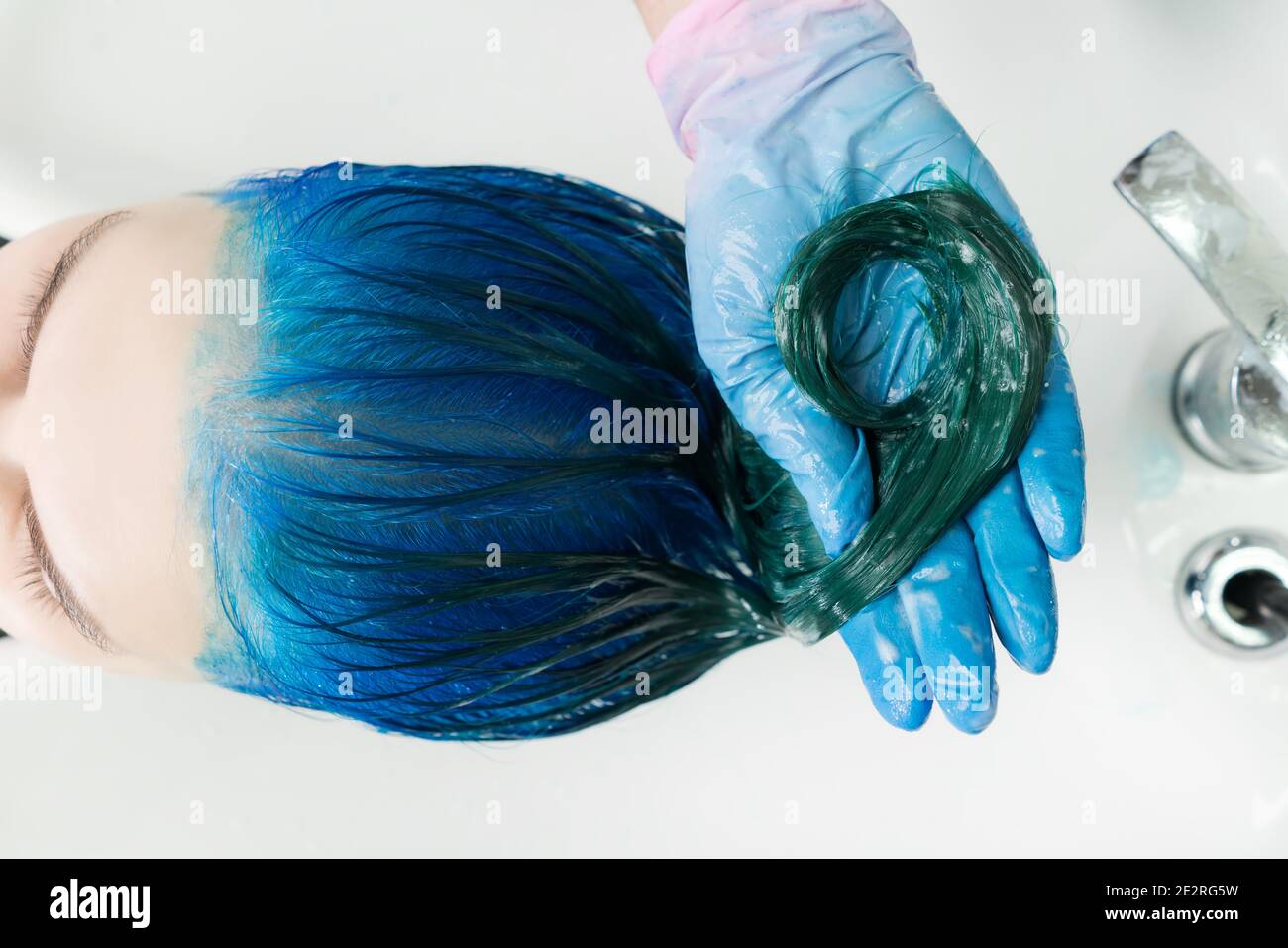 Washing of woman hair with conditioner shampoo in sink with special ...