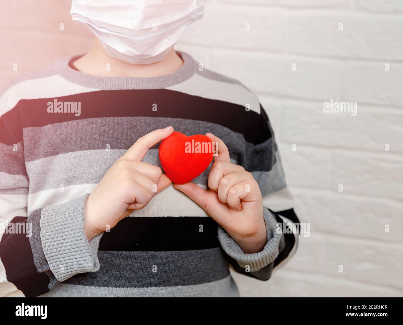 Sad and desperate child boy holding red toy heart in hands Stock Photo ...