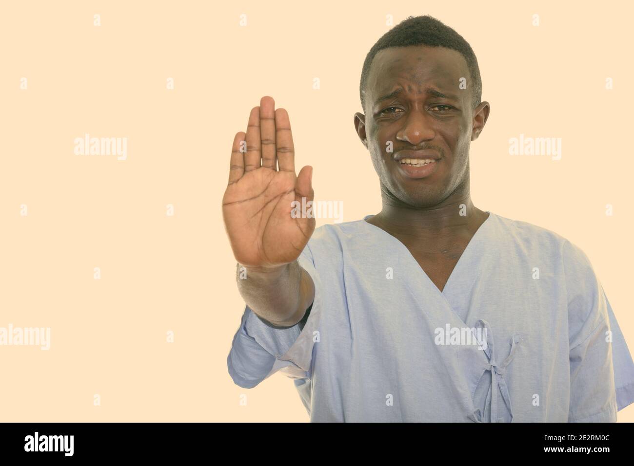 Studio shot of young black African man patient looking sad while giving ...