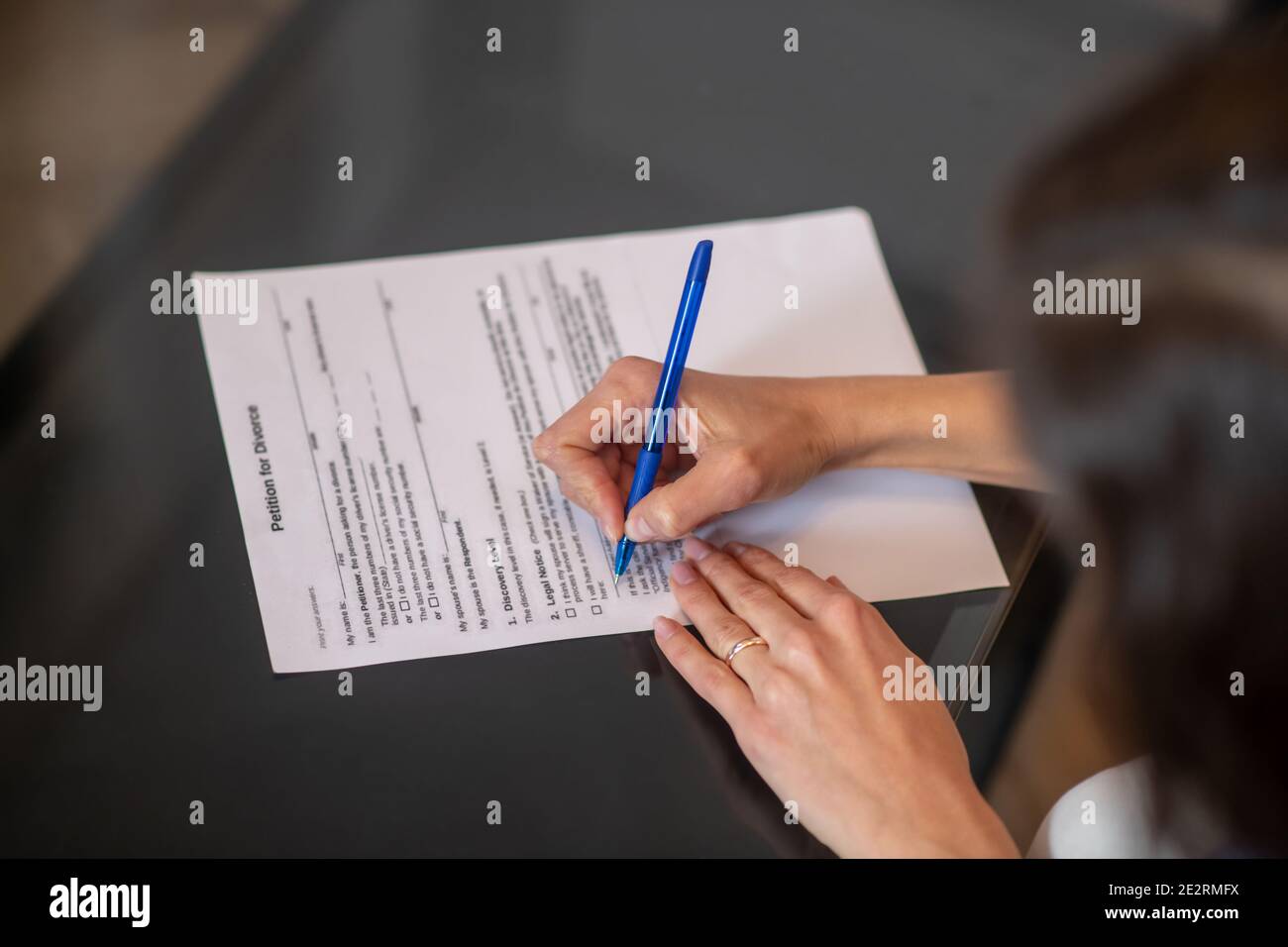 Woman signing a petition for divorce with a pen Stock Photo - Alamy