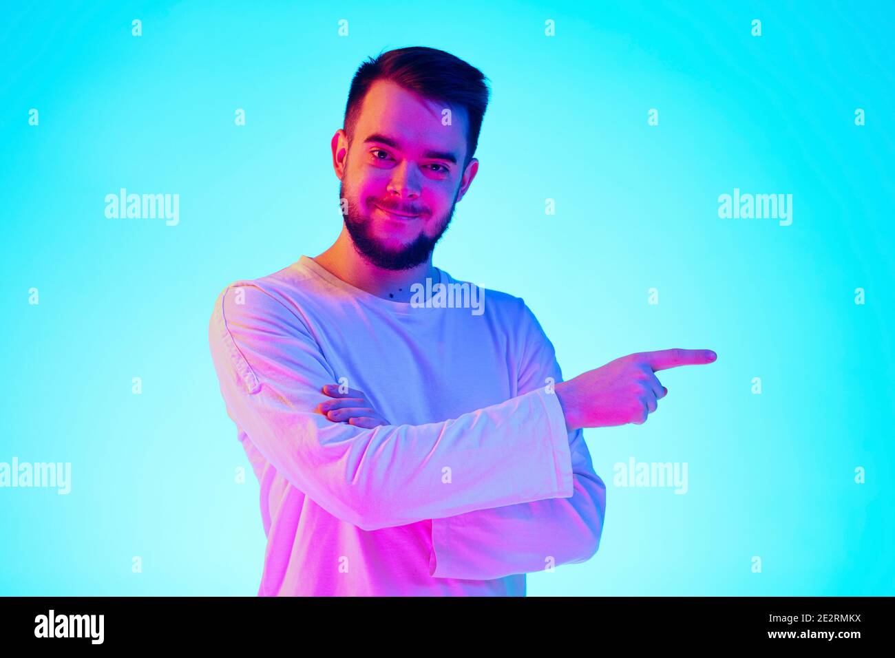 Pointing, choosing. Caucasian man's portrait isolated on blue studio ...