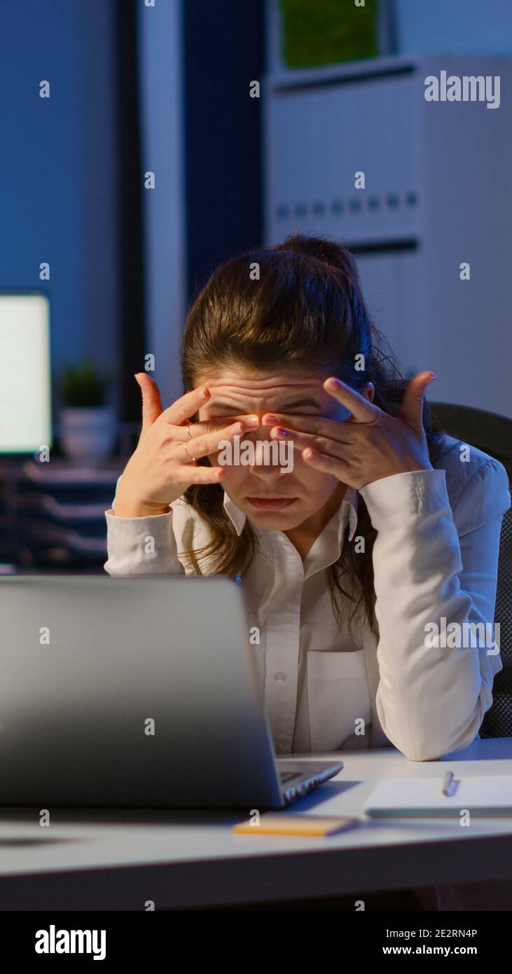 Stressed businesswoman suffering from headache at work doing overtime ...