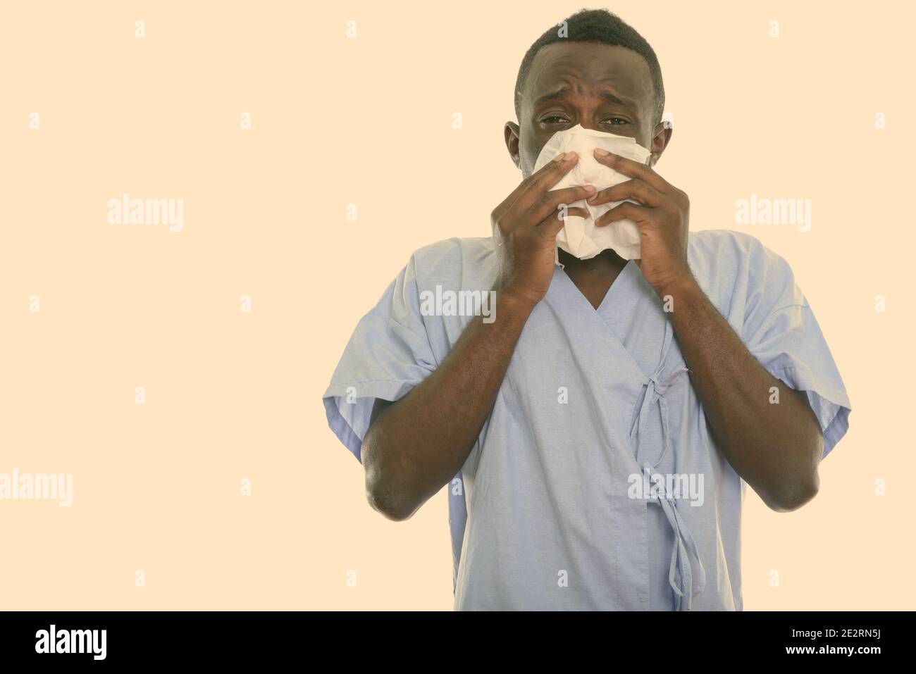 Studio shot of young black African man patient looking sick while ...