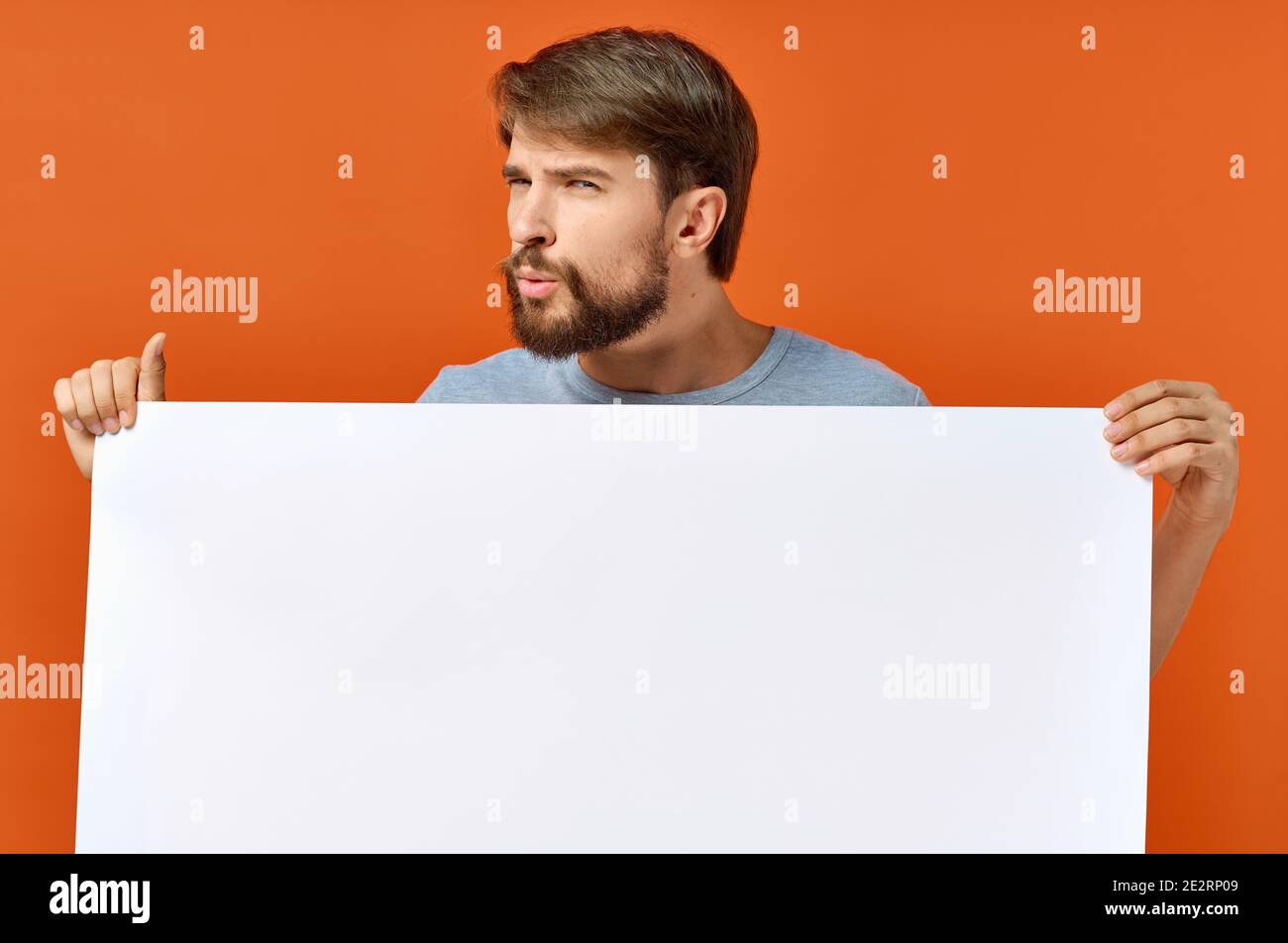 emotional guy holding a white sheet of paper in his hands Poster mockup ...