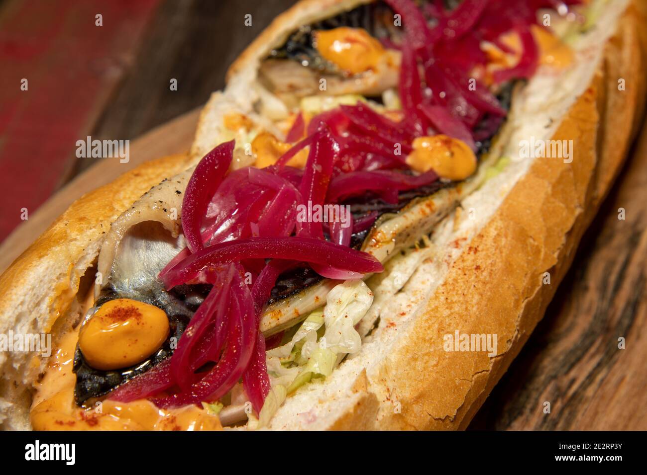 A delicious Grilled Mackerel fish Baguette on a wooden kitchen table ...