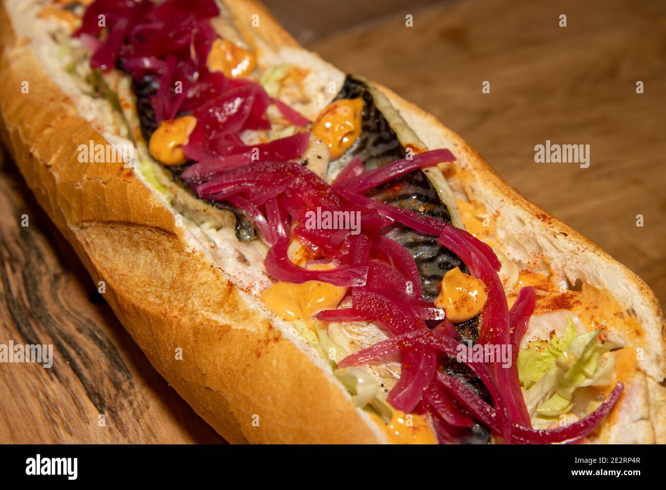 A delicious Grilled Mackerel fish Baguette on a wooden kitchen table ...