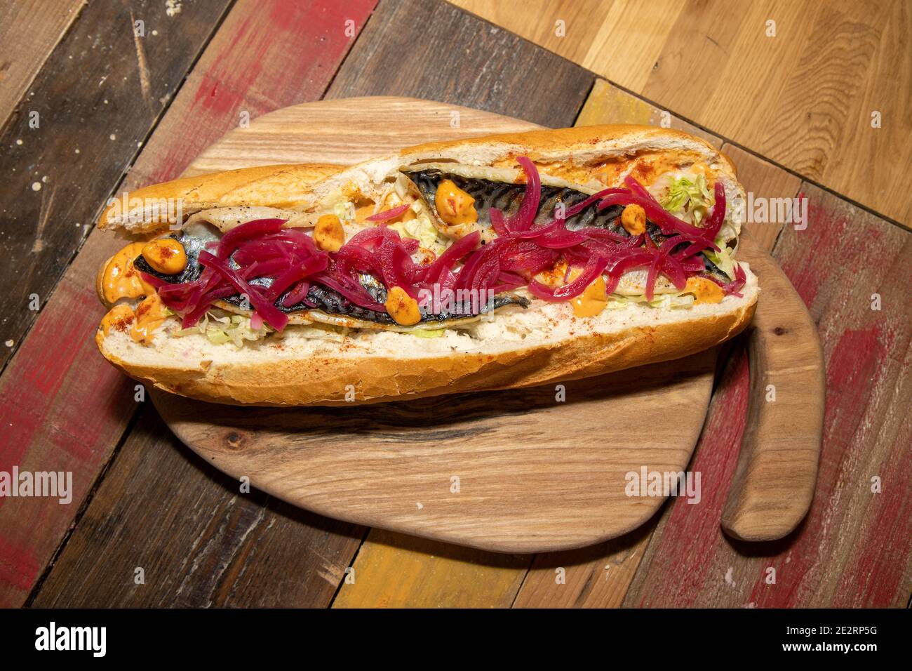 A delicious Grilled Mackerel fish Baguette on a wooden kitchen table ...