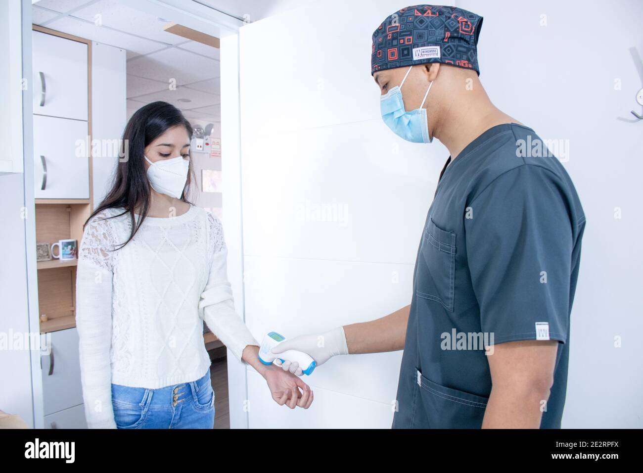 Doctor checking a female's temperature before entering the clinic Stock ...