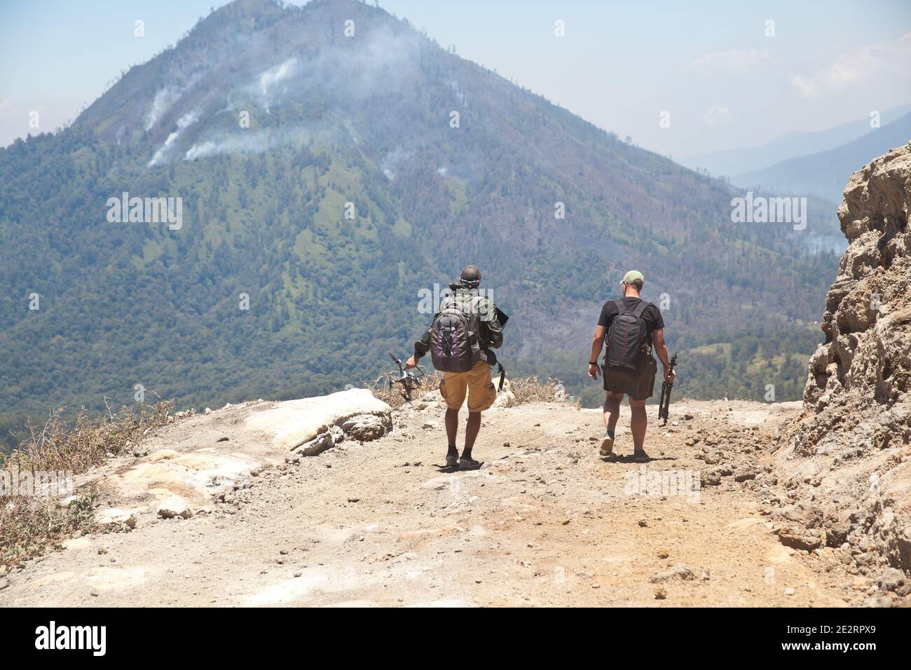 Travelers on the mountains. Two men are walking along a mountain road ...