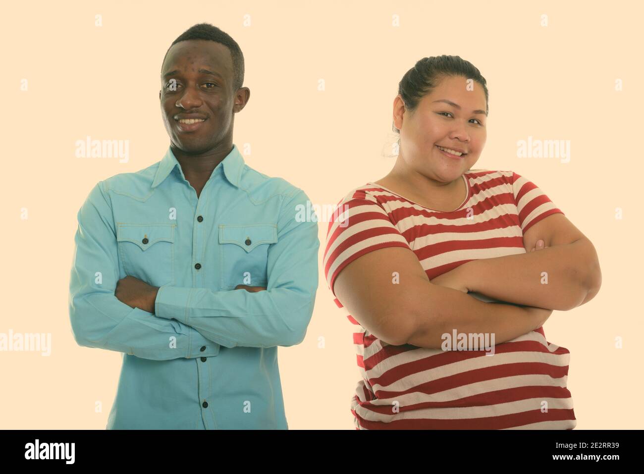 Happy young fat Asian woman and young black African man smiling with ...