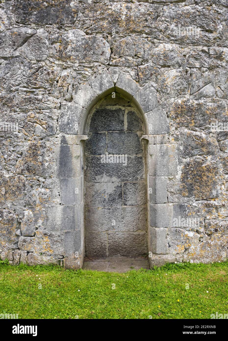 A stone wall and arch of a historic building constucted from ...