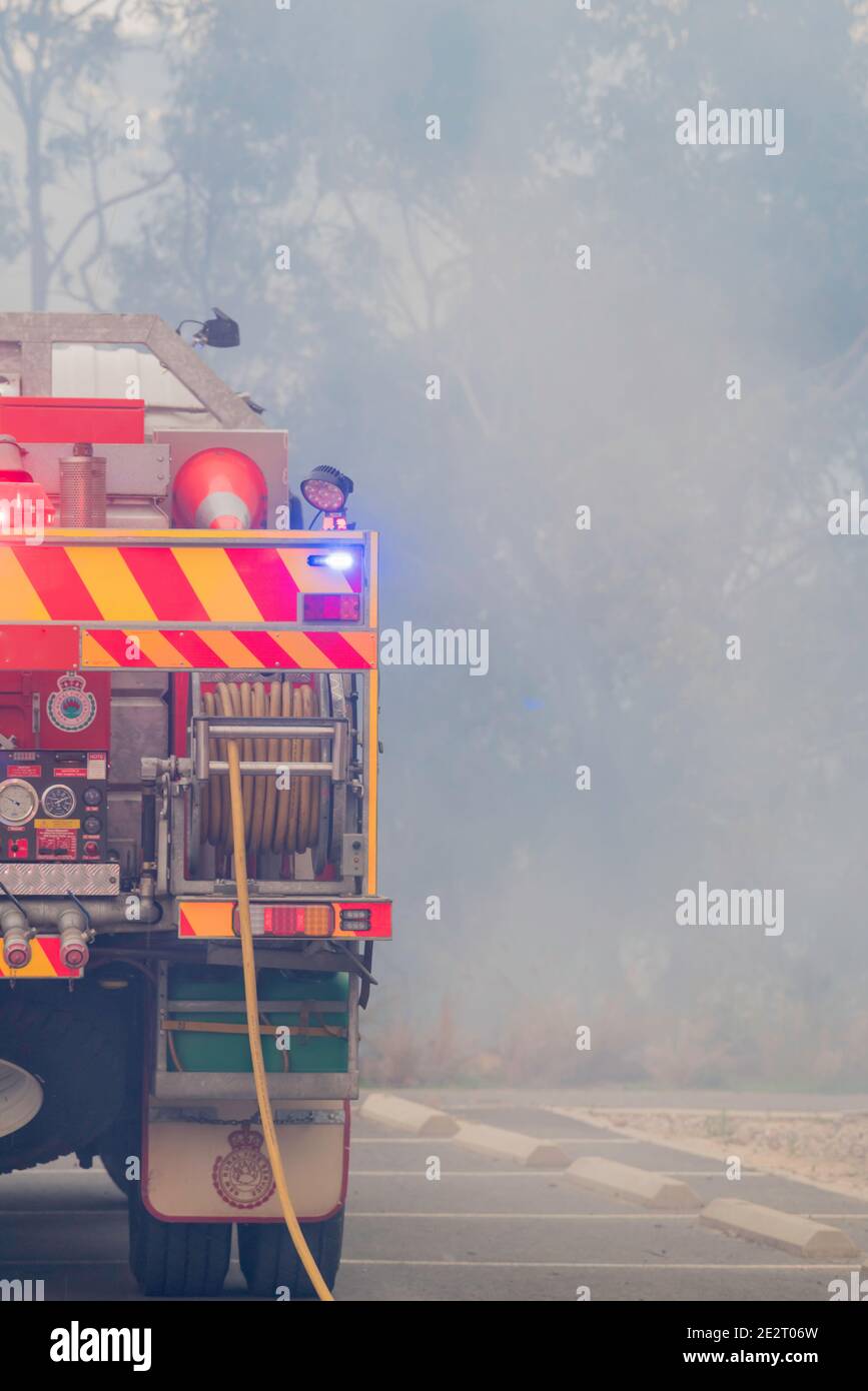 The back of a Rural Fire Service truck with lights flashing, surrounded ...