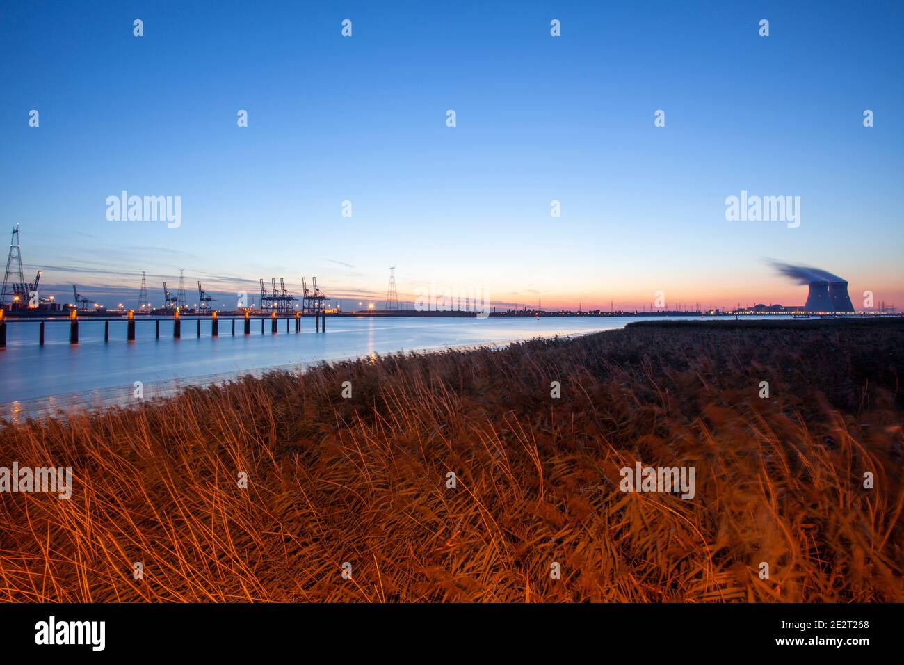 Jetty at the river Scheldt, with in the distance a view of the cooling ...