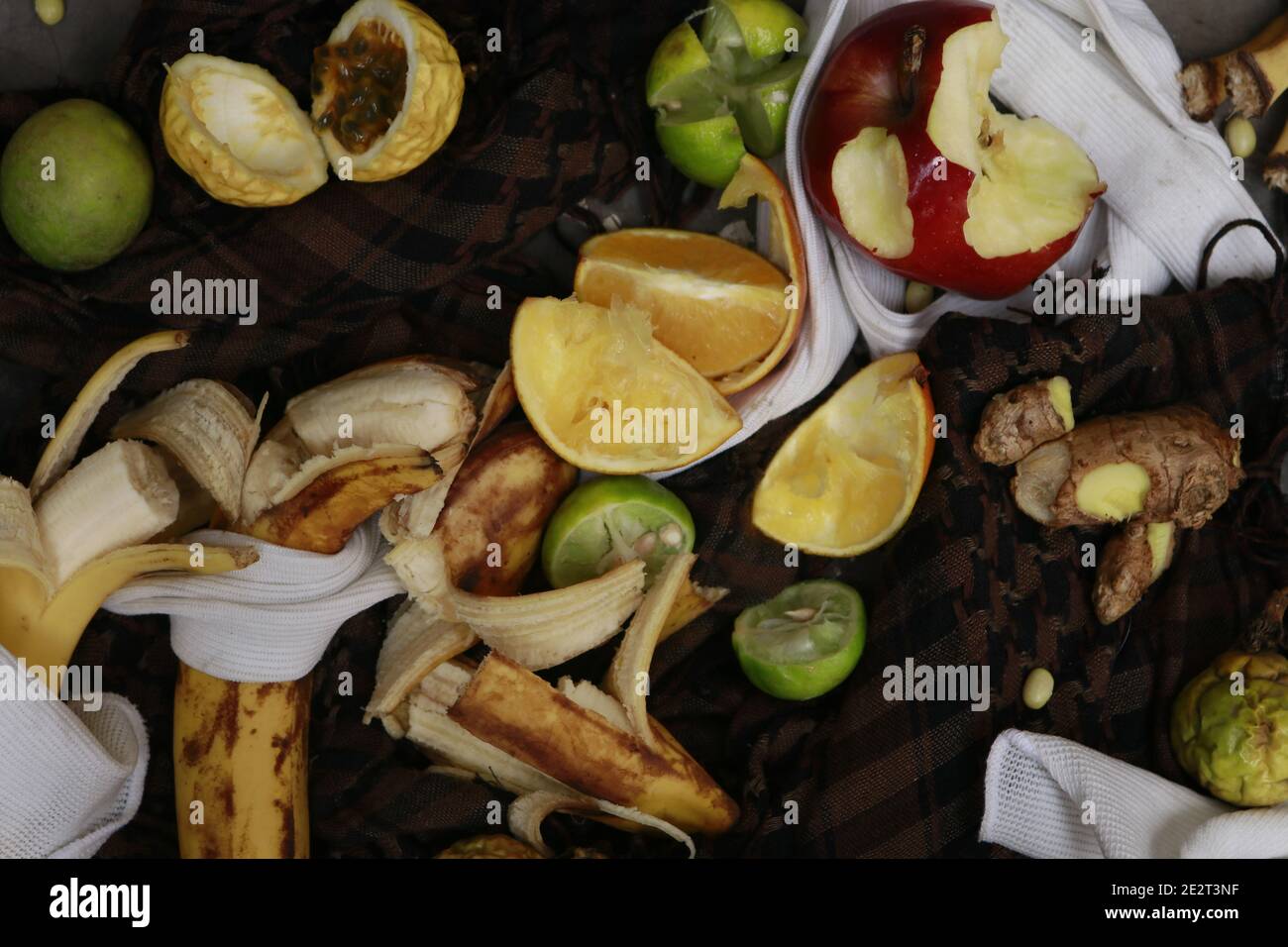 Top view of half-eaten fruits and vegetables on a table - wasting food ...