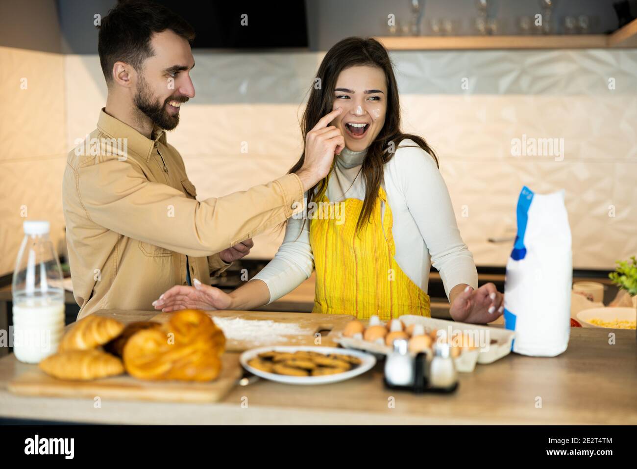 Couple are having fun while cooking. They look happy being together in ...