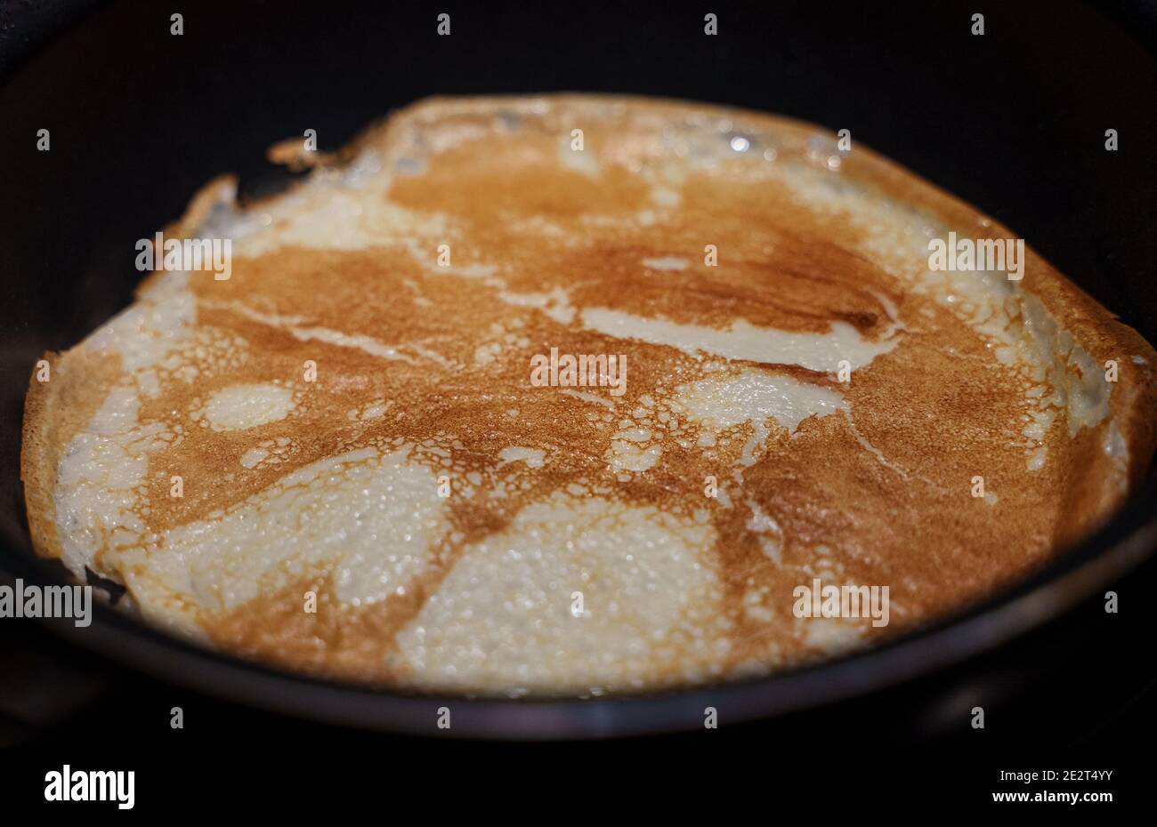 Pancake on frying pan. Making of pancakes Stock Photo - Alamy