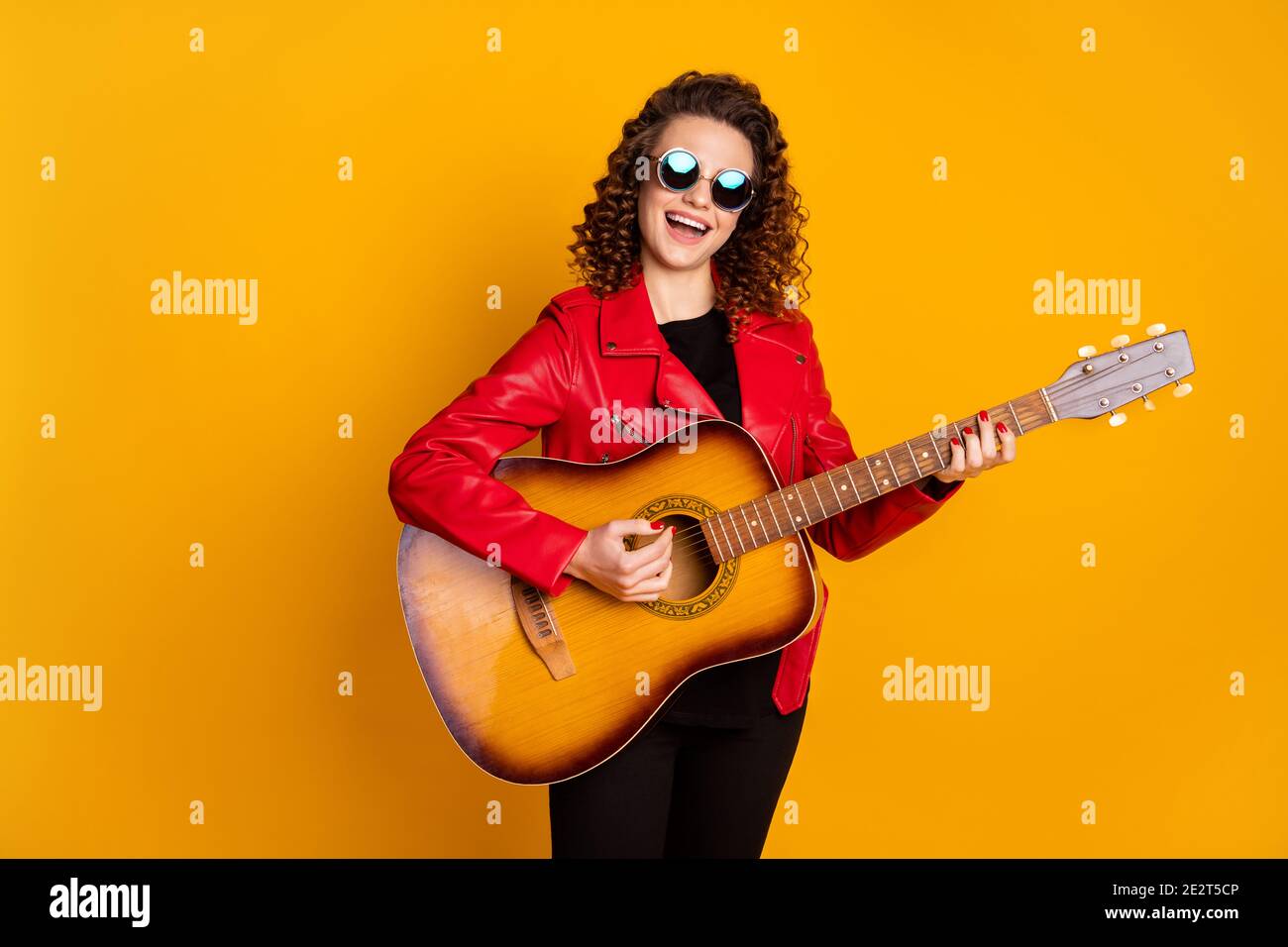 Portrait of attractive cheerful famous wavy-haired girl playing guitar ...