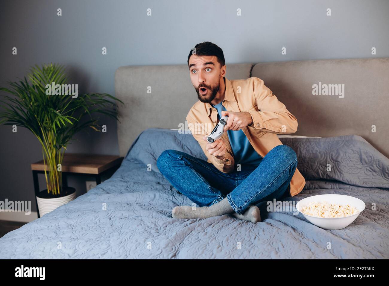 Young attractive man playing console game in front of camera, beating ...