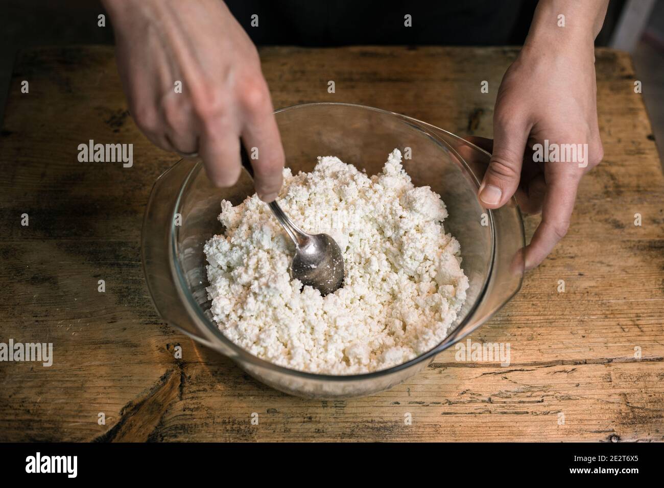 Stir the curd with a spoon in a glass bowl Stock Photo - Alamy