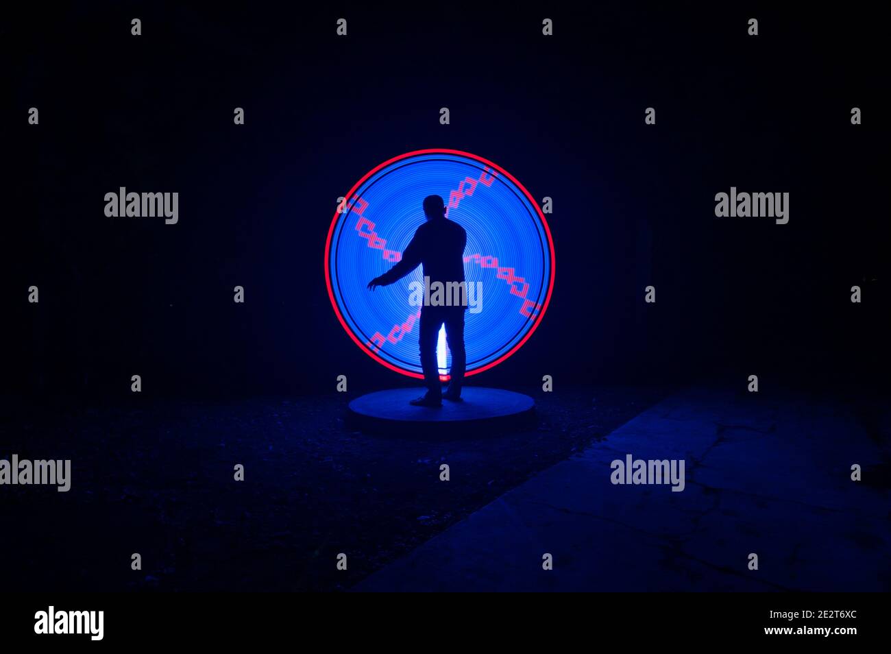 One person standing alone against beautiful color circle LED light ...