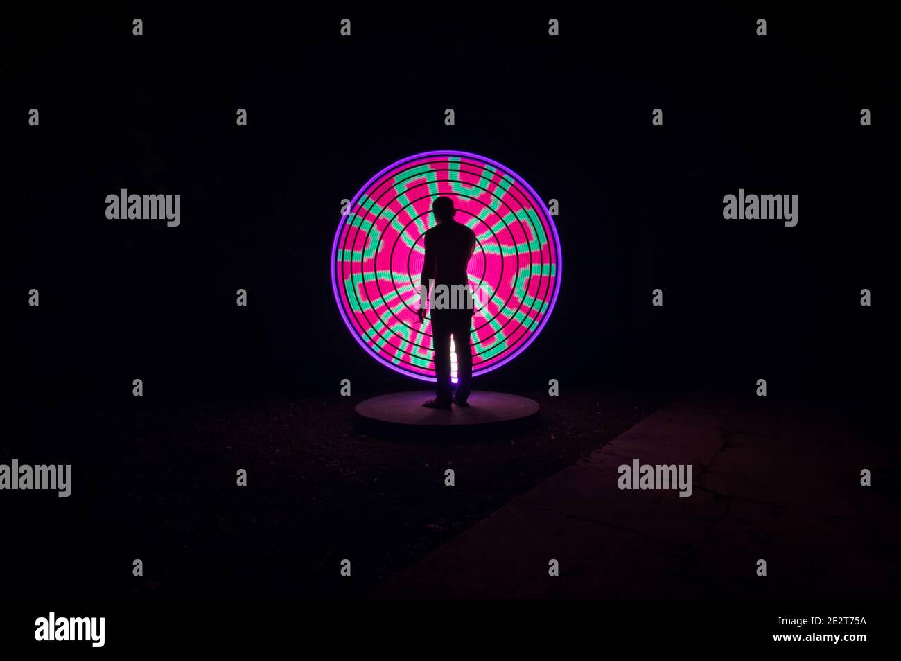 One person standing alone against beautiful color circle LED light ...