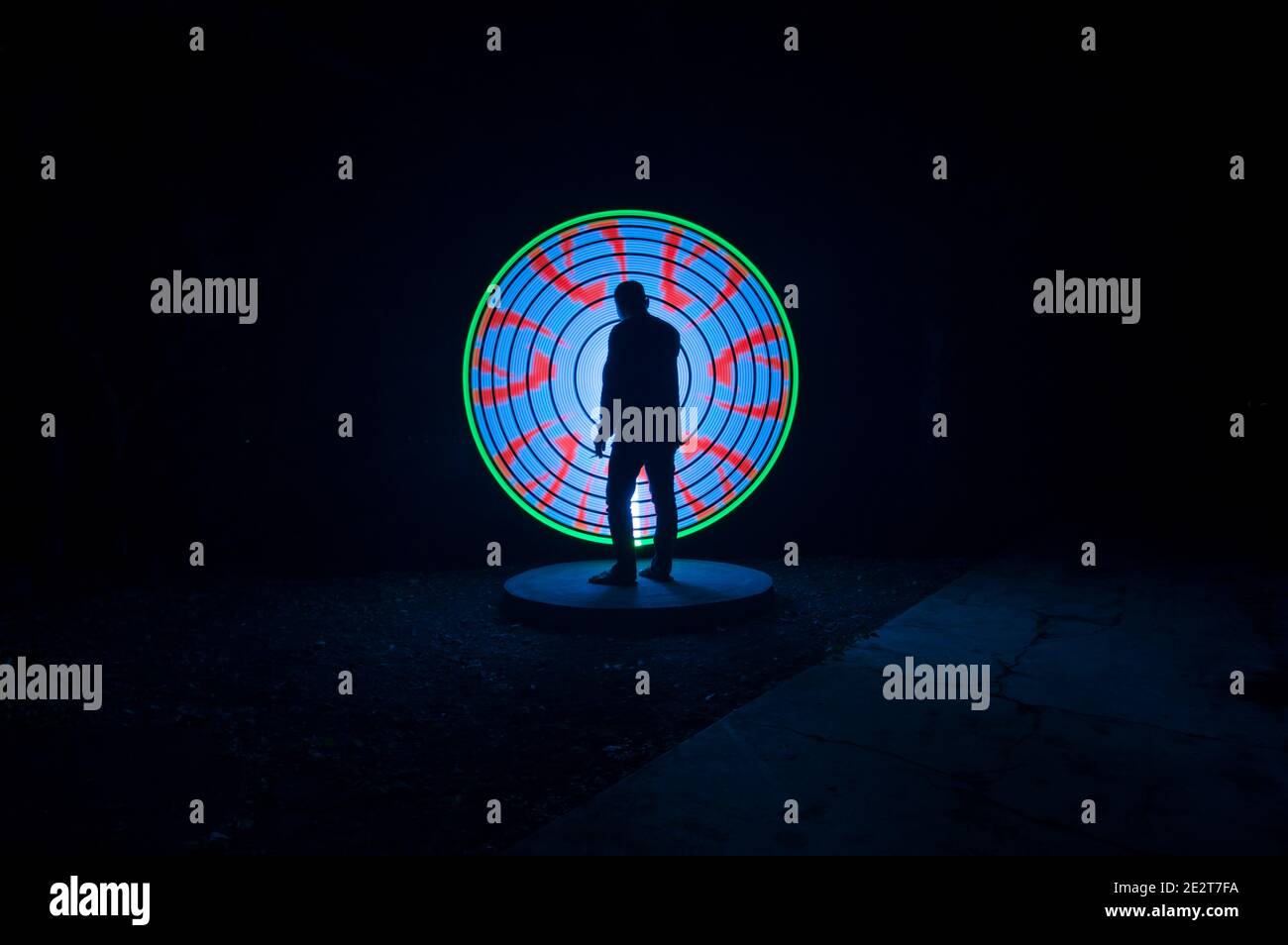 One person standing alone against beautiful color circle LED light ...