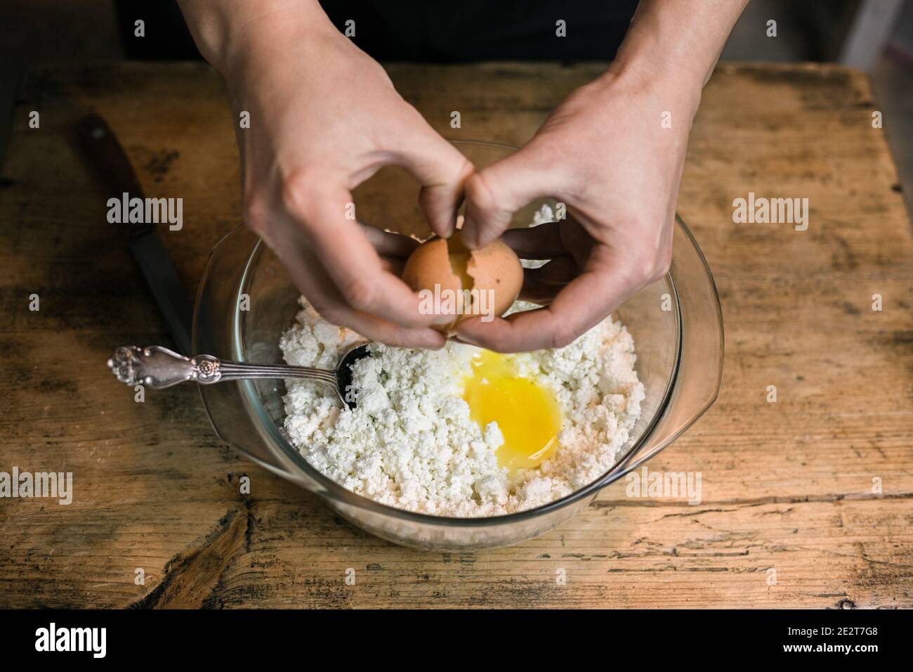 Breaks a chicken egg and adds to the curd Stock Photo - Alamy