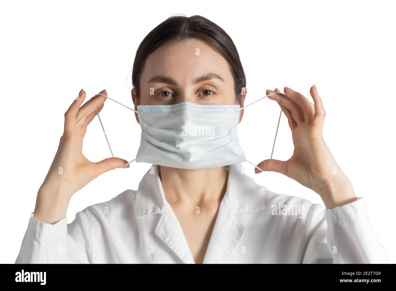 Cute female doctor, nurse puts on a medical face mask, respirator ...
