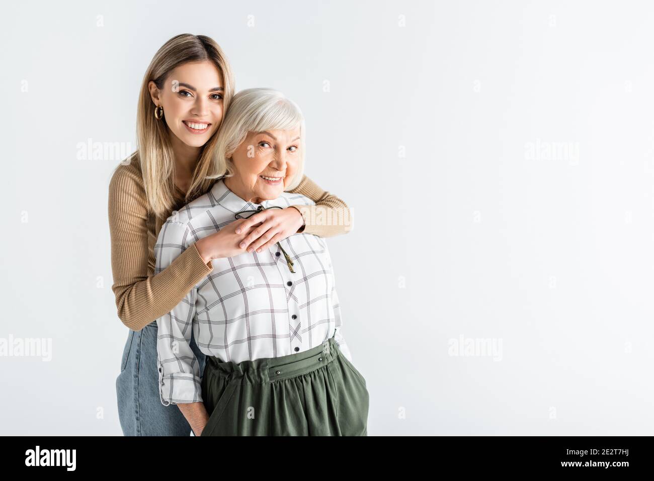 Cheerful Granddaughter Hugging Senior Granny Isolated On White Stock
