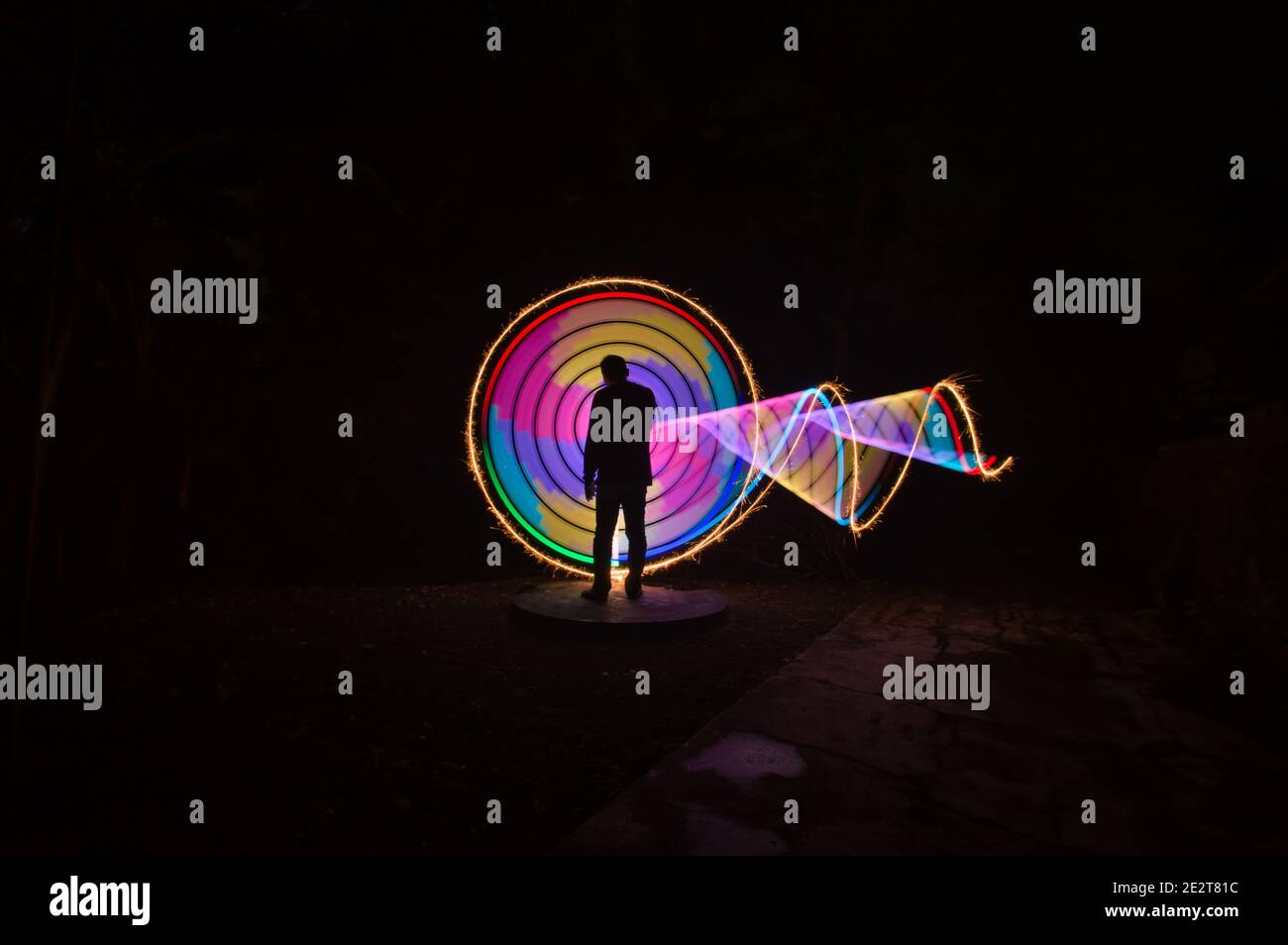 One person standing alone against beautiful color circle LED light ...