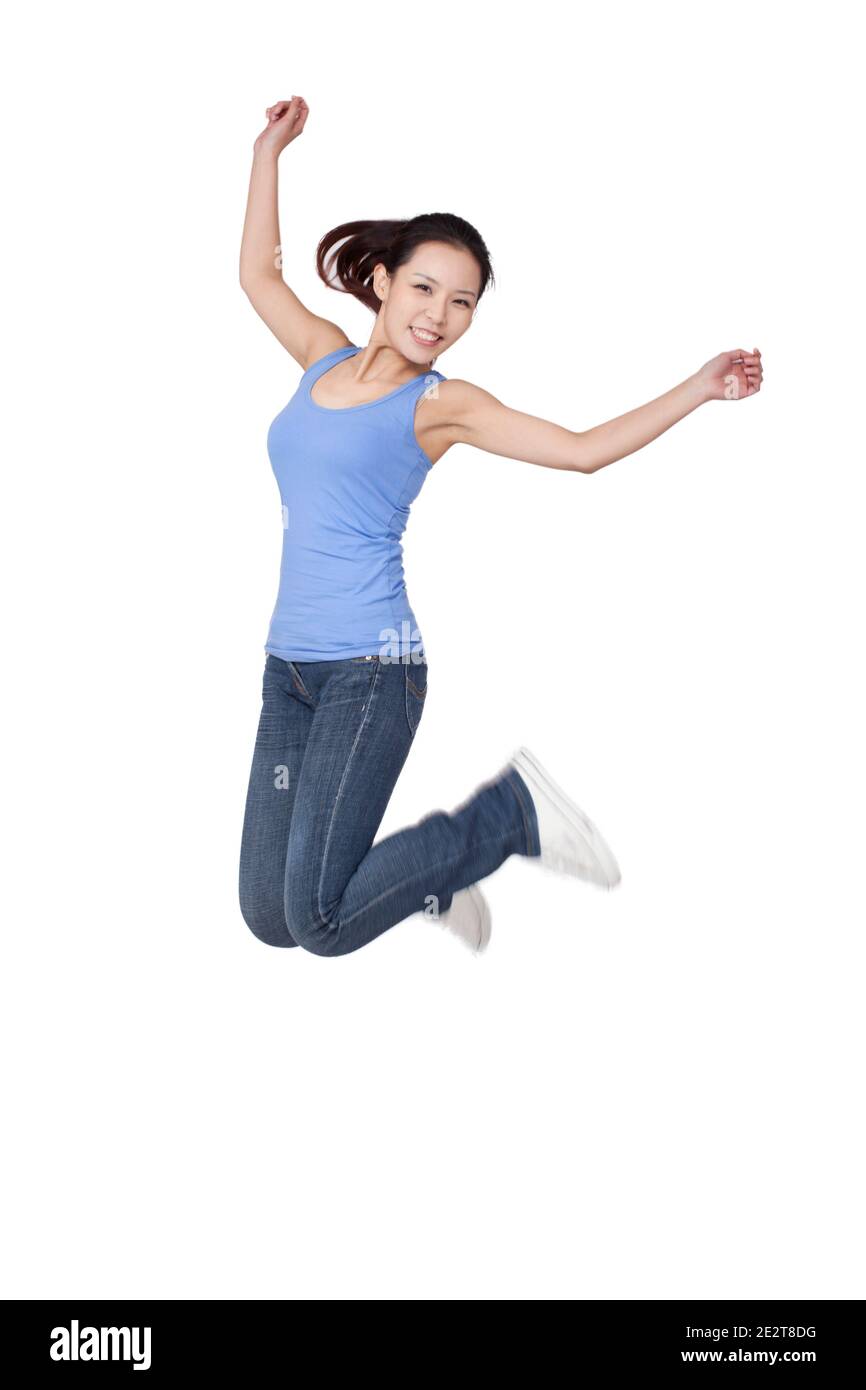 Young woman jumping in air with arms outstretched,on white background ...