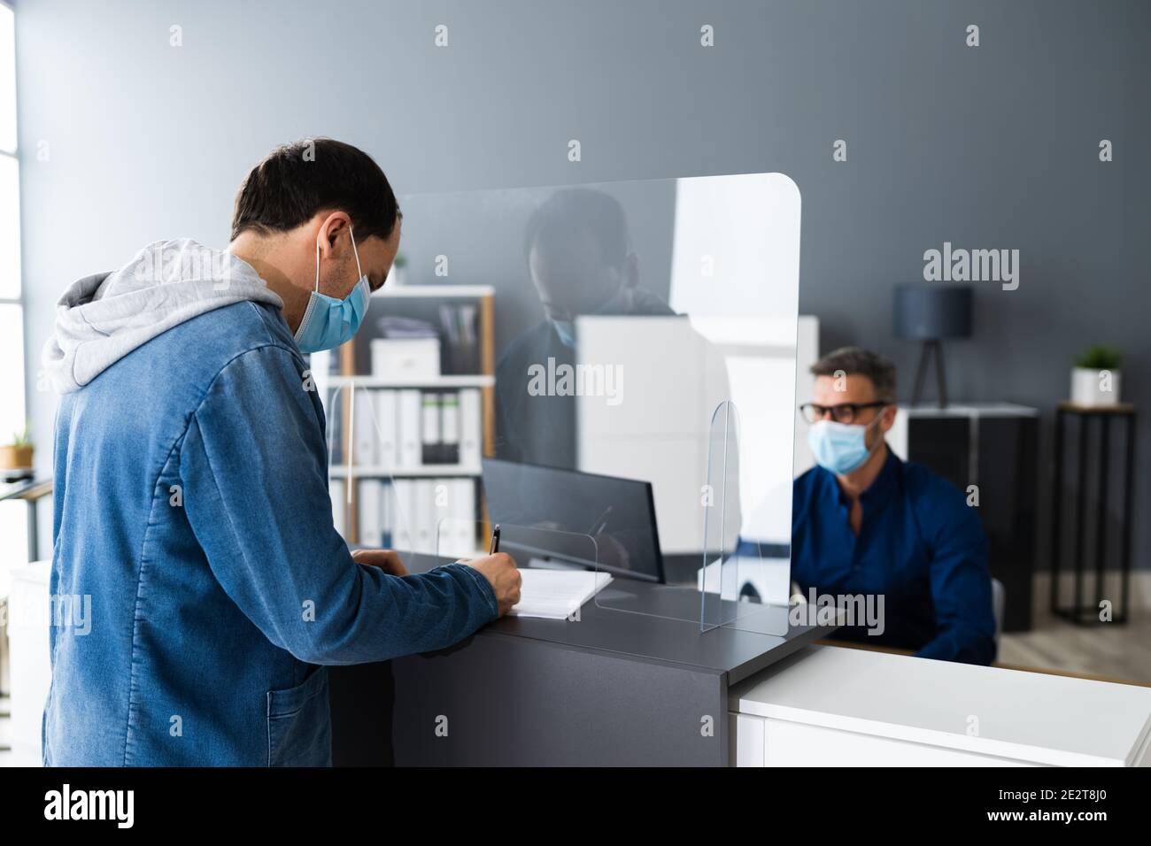 Hotel Reception Counter Desk In Covid Face Mask Stock Photo - Alamy