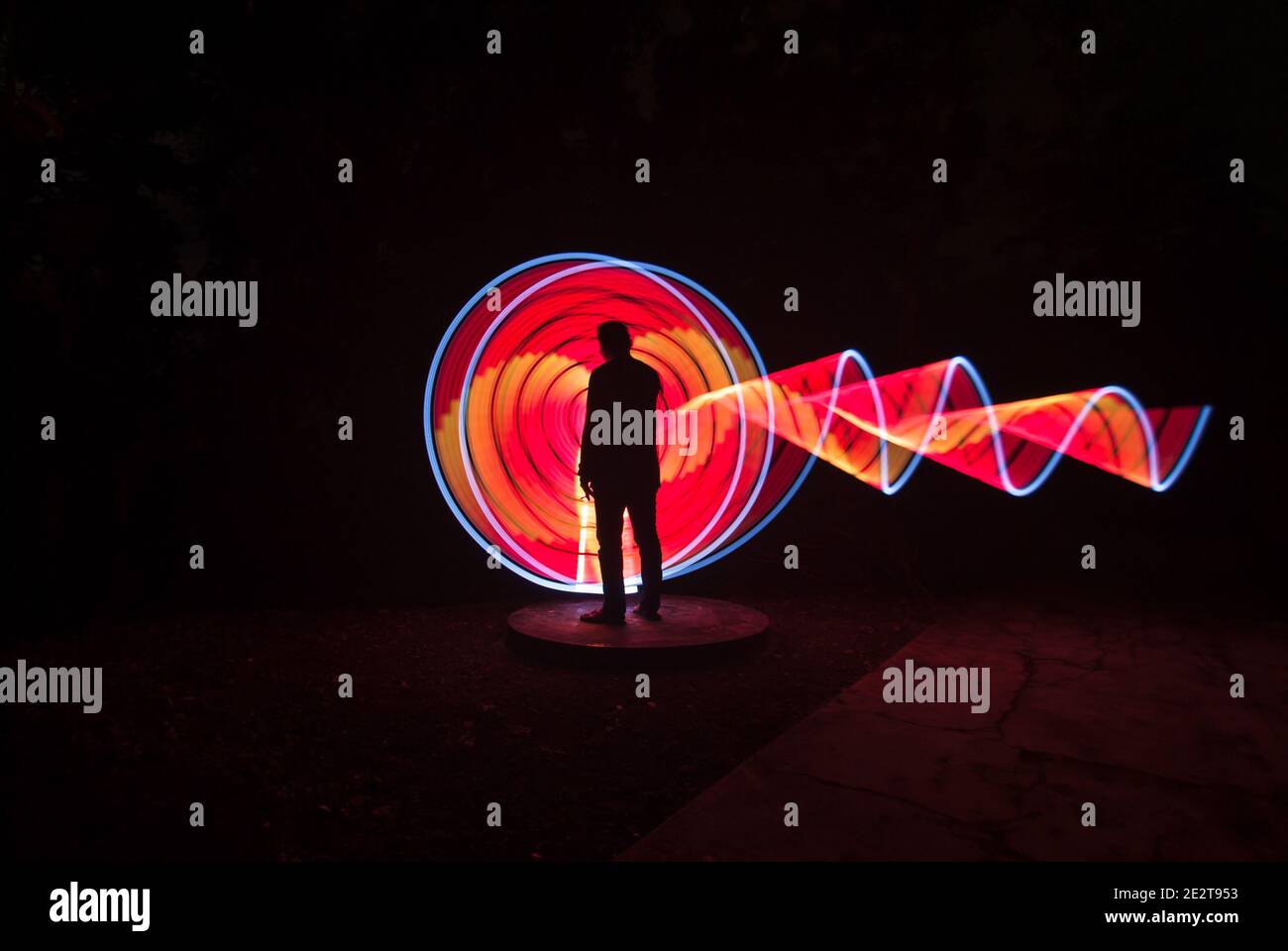 One person standing alone against beautiful color circle LED light ...