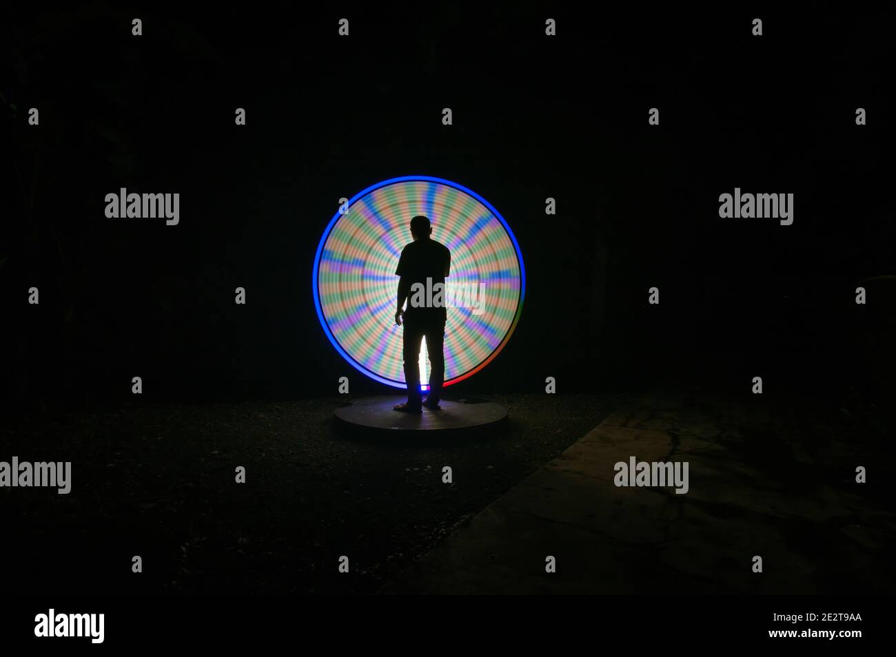 One person standing alone against beautiful color circle LED light ...