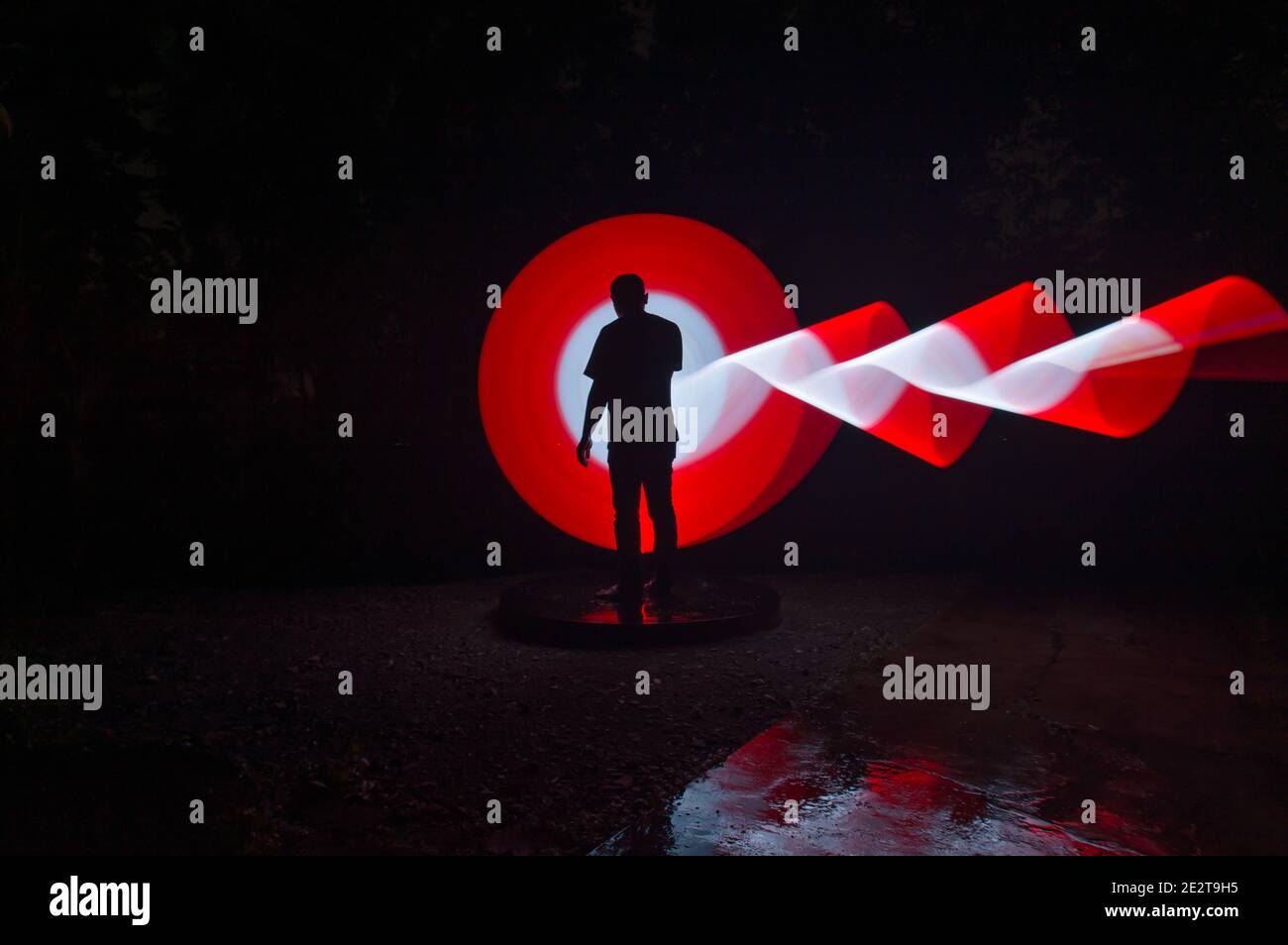 One person standing alone against beautiful color circle LED light ...