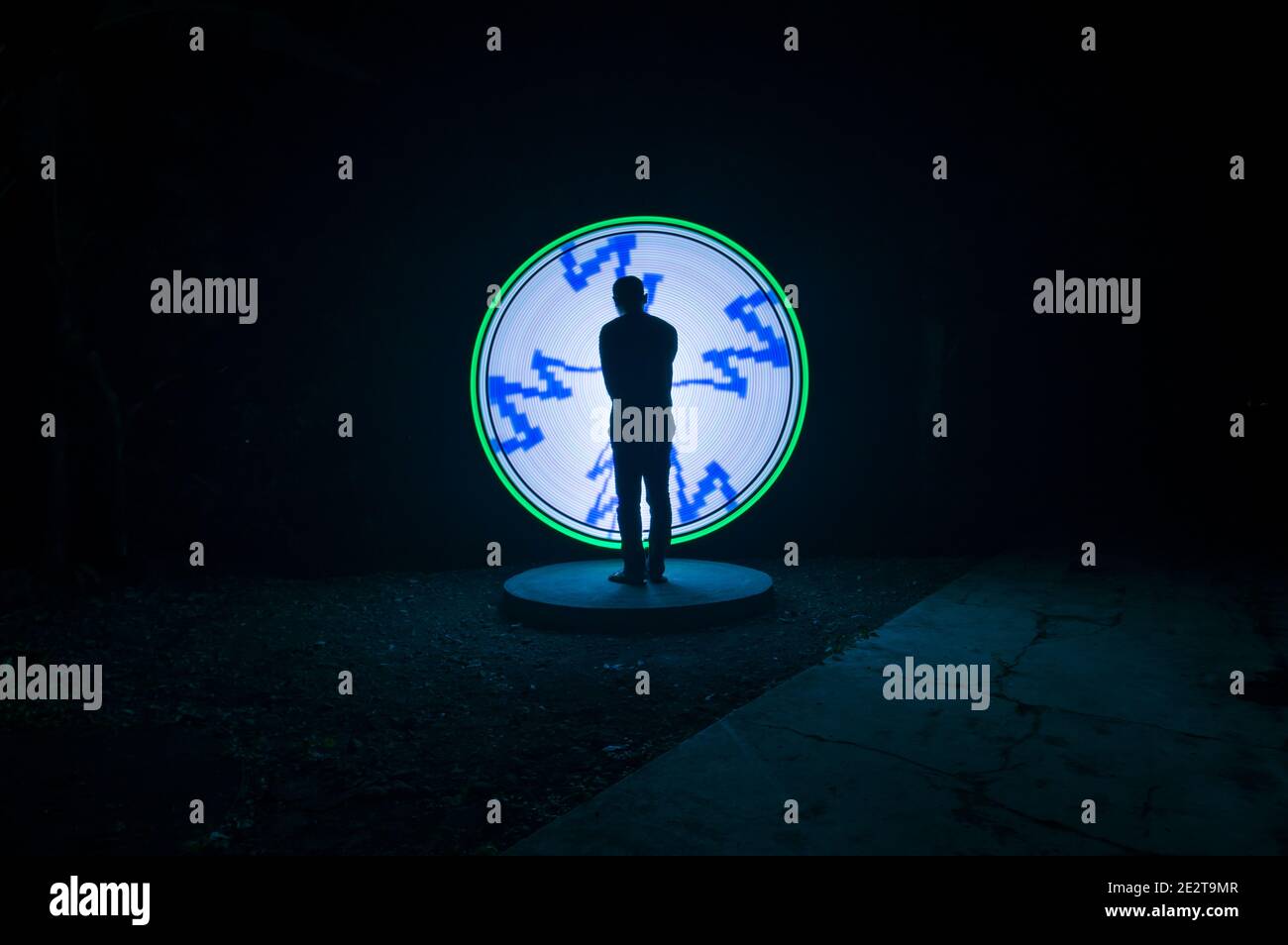 One person standing alone against beautiful color circle LED light ...